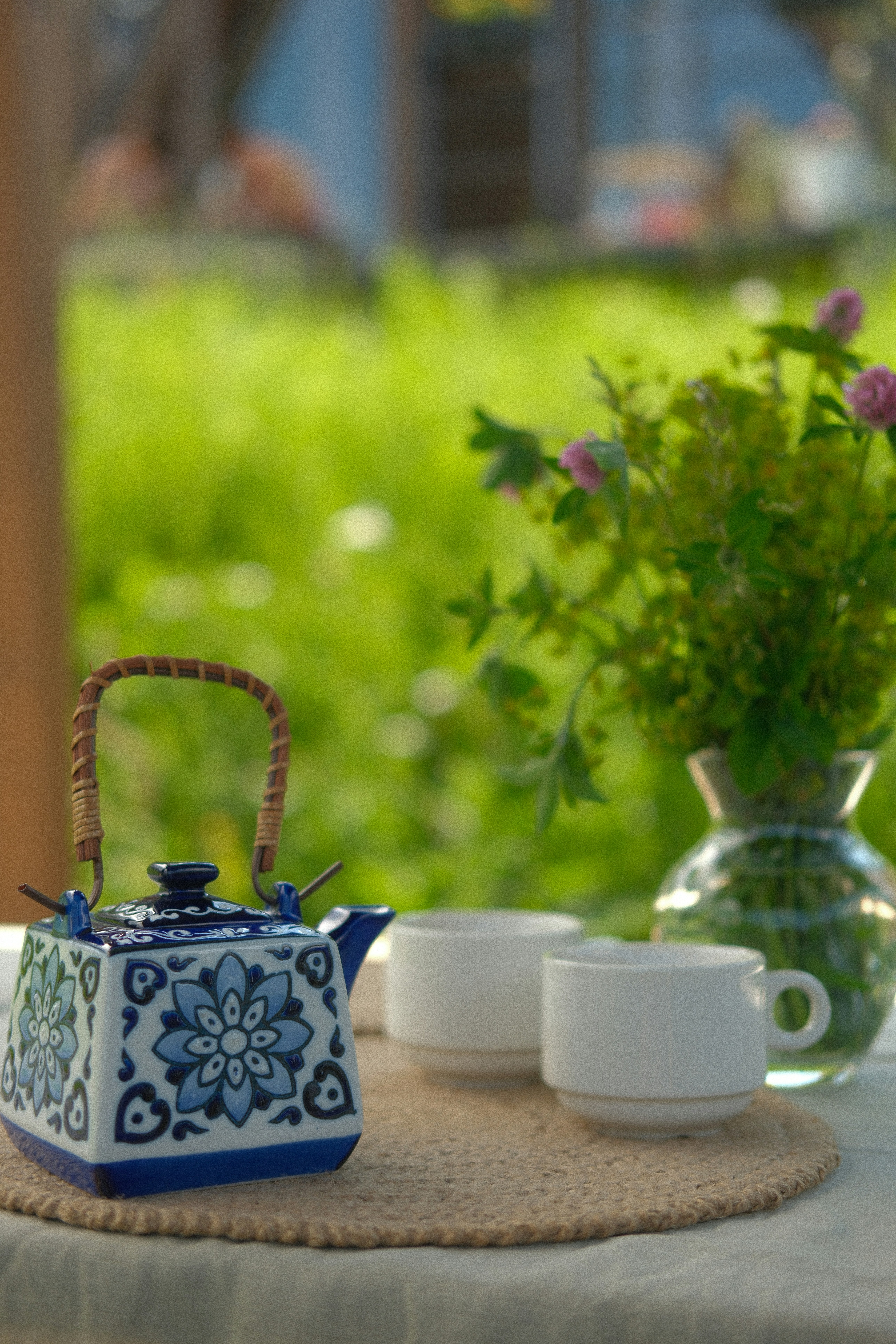 Ceramic teapot and bloom at a sunlit garden tea set