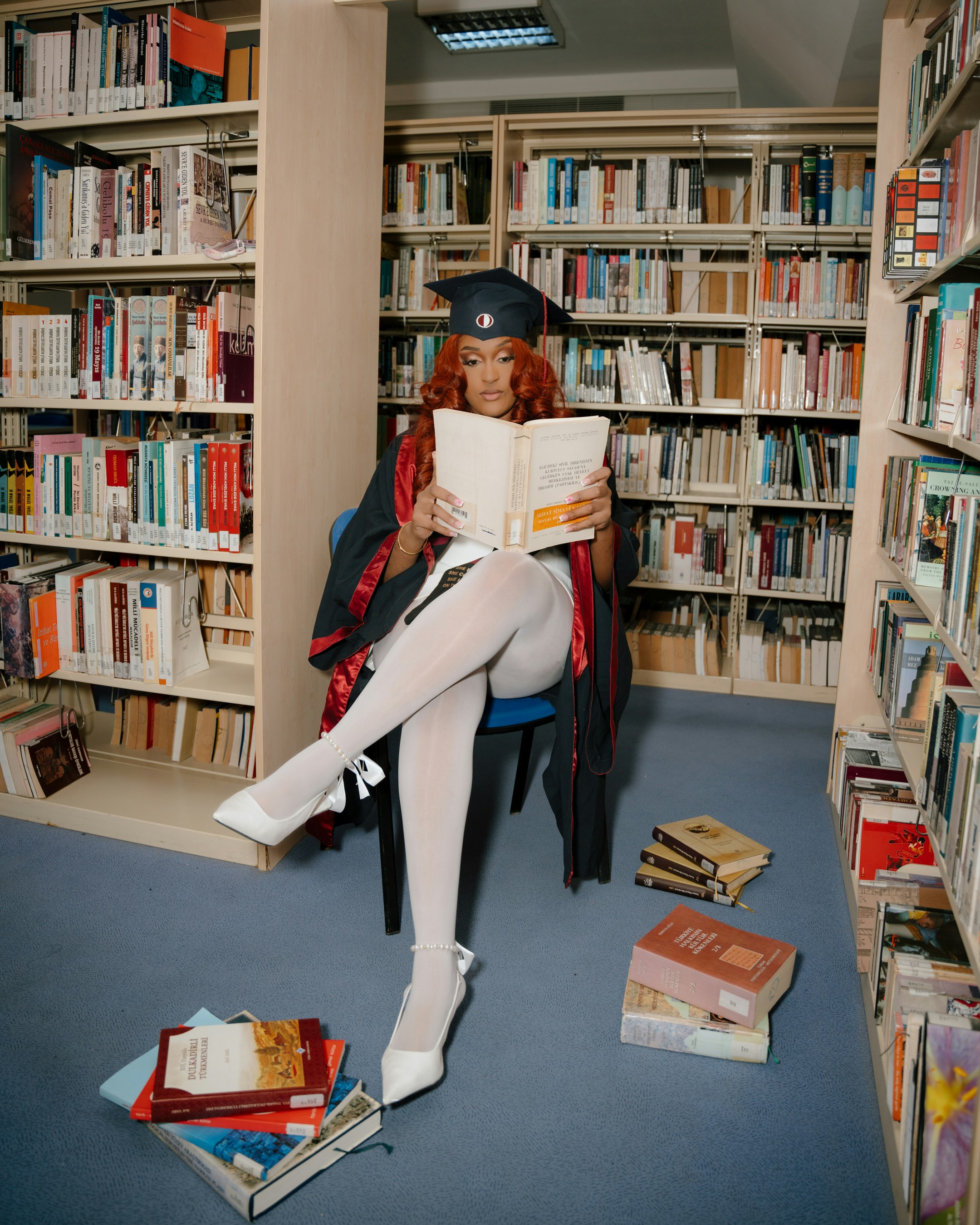 Bookish Bloom: A Graduate in Focus Amid Stacks