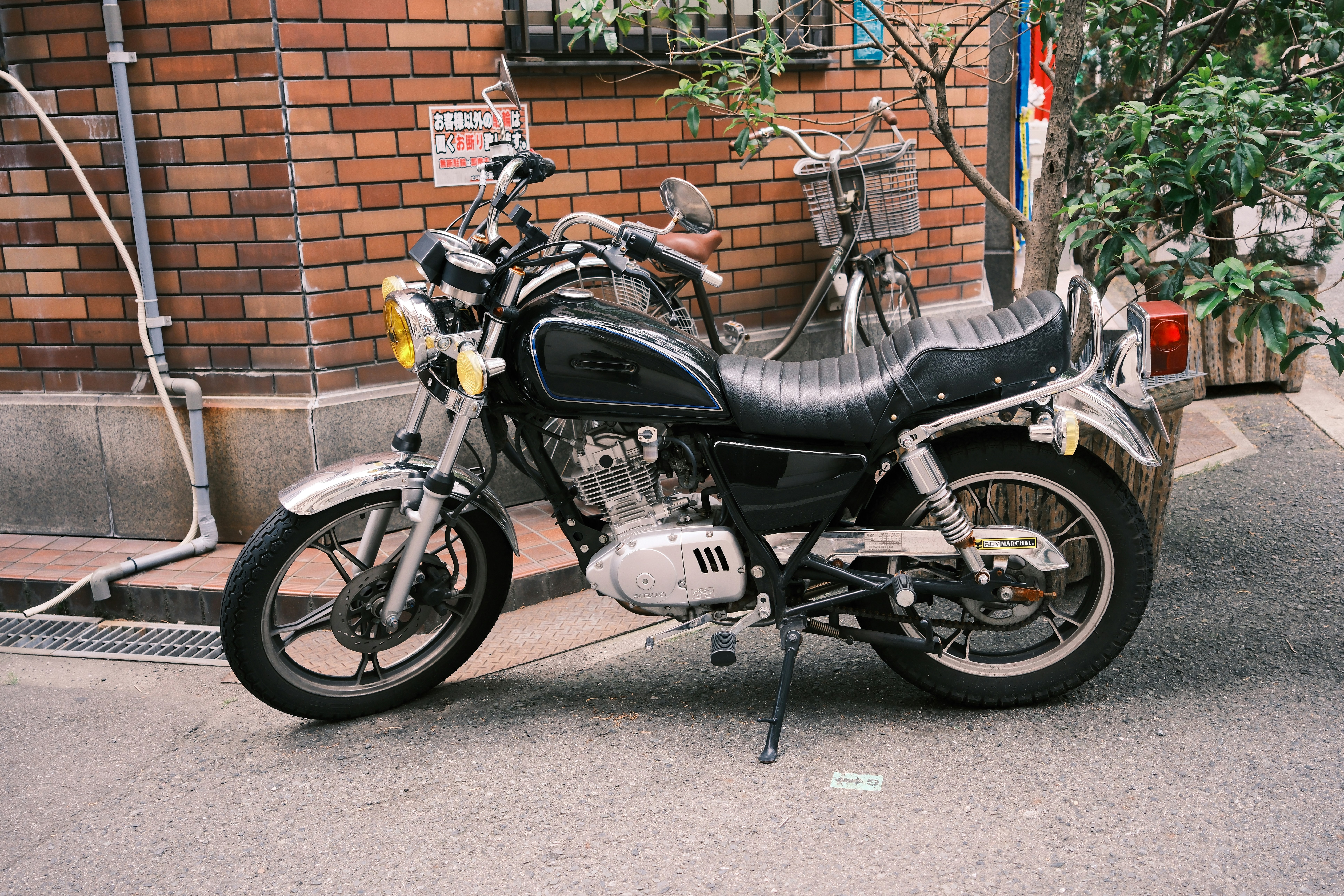Midnight Glide: Classic Motorcycle Poised by an Urban Brick Wall
