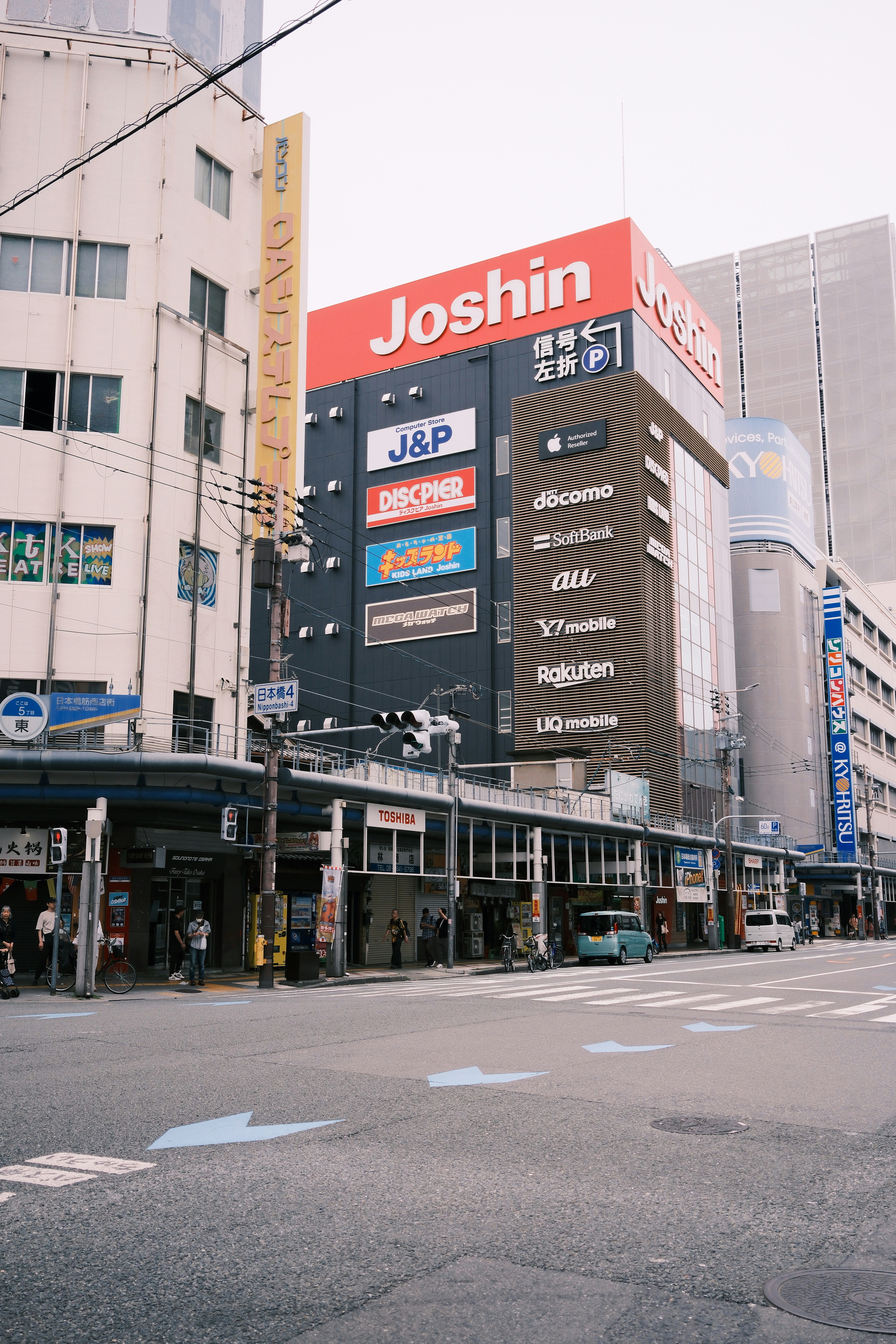 Japanese city street with a large joshin electronics store.