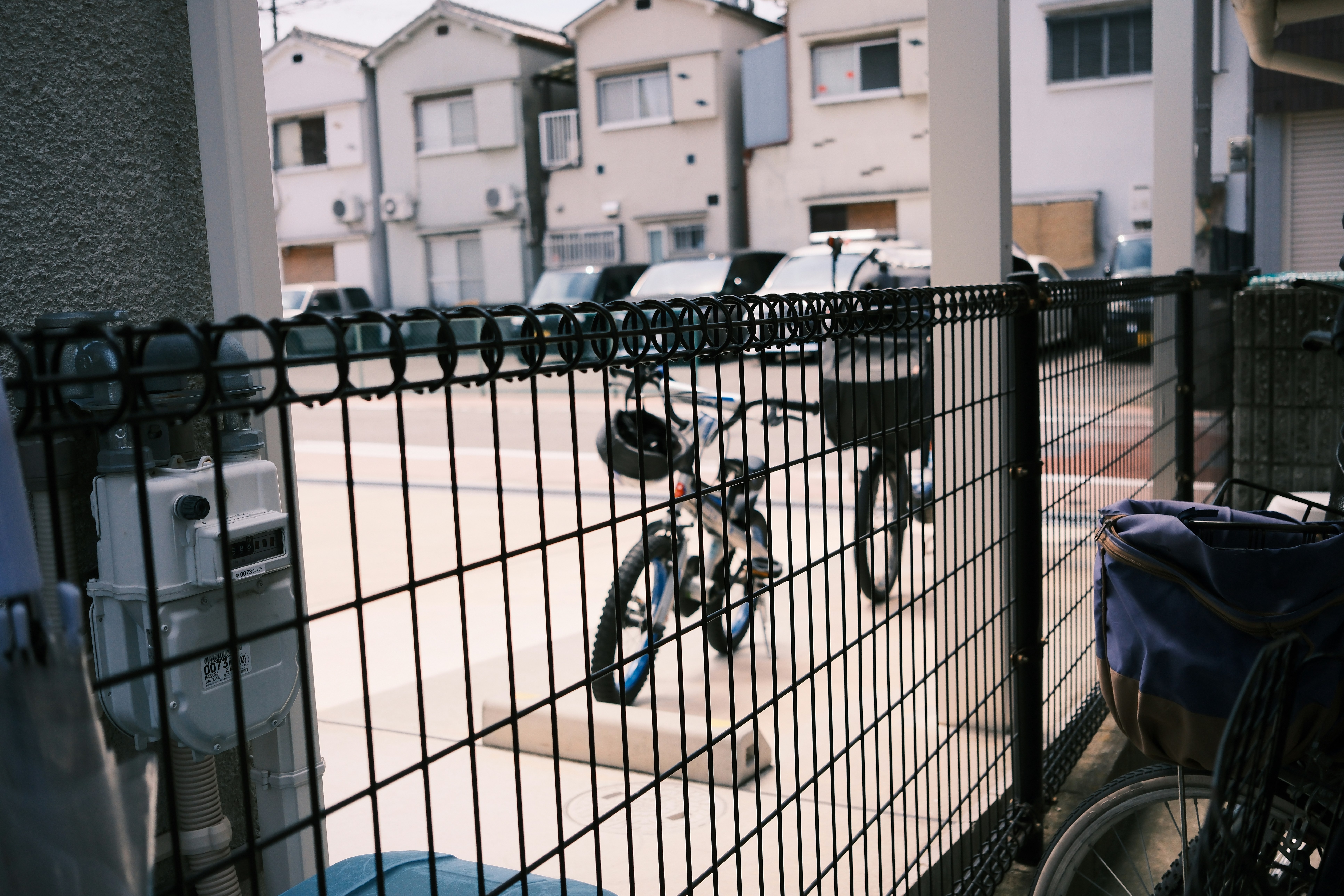 Bike Waiting Behind the Fence: Quiet Street Corner