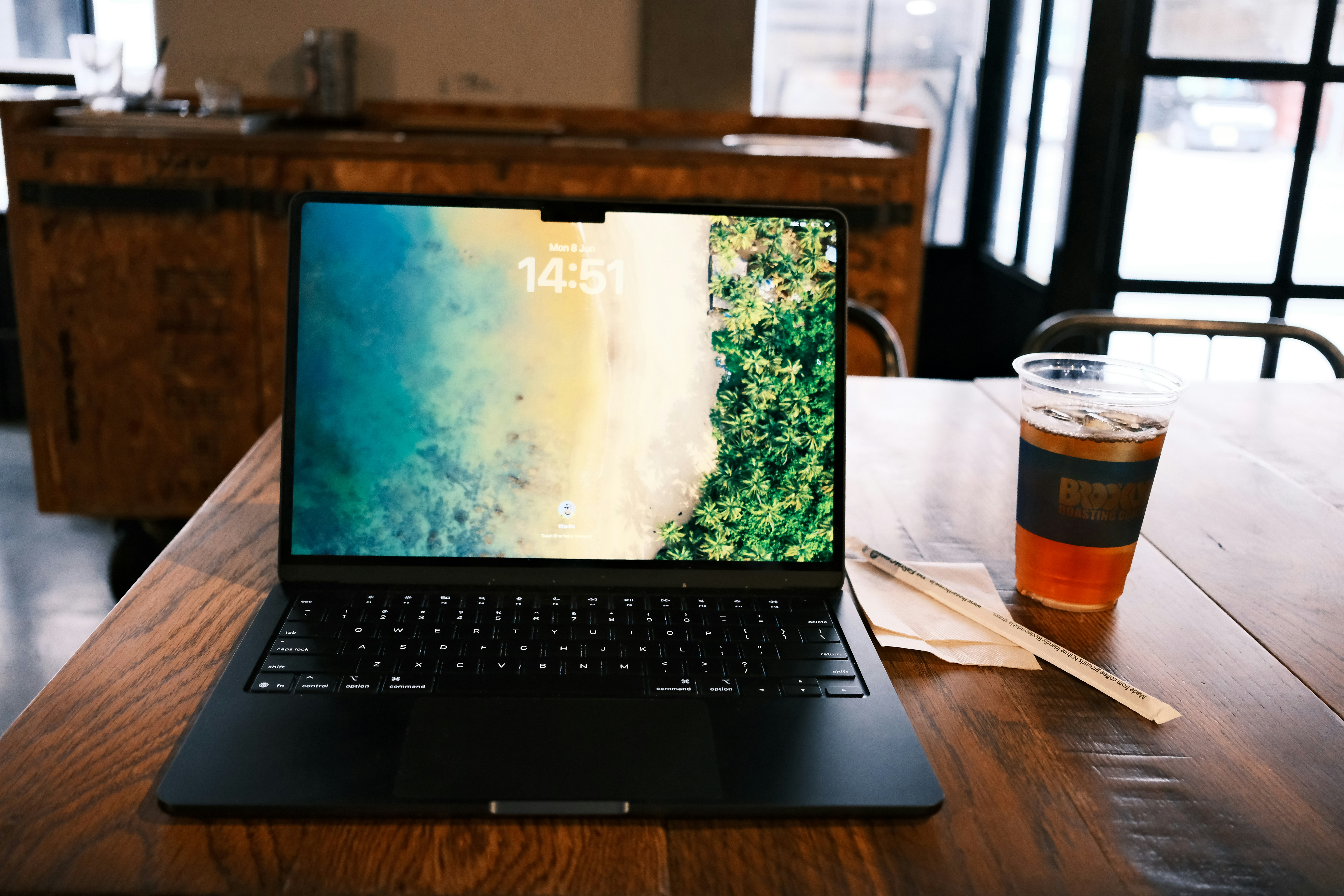 Morning Spotlight on a Quiet Workspace: Laptop Framed by Coffee and Light