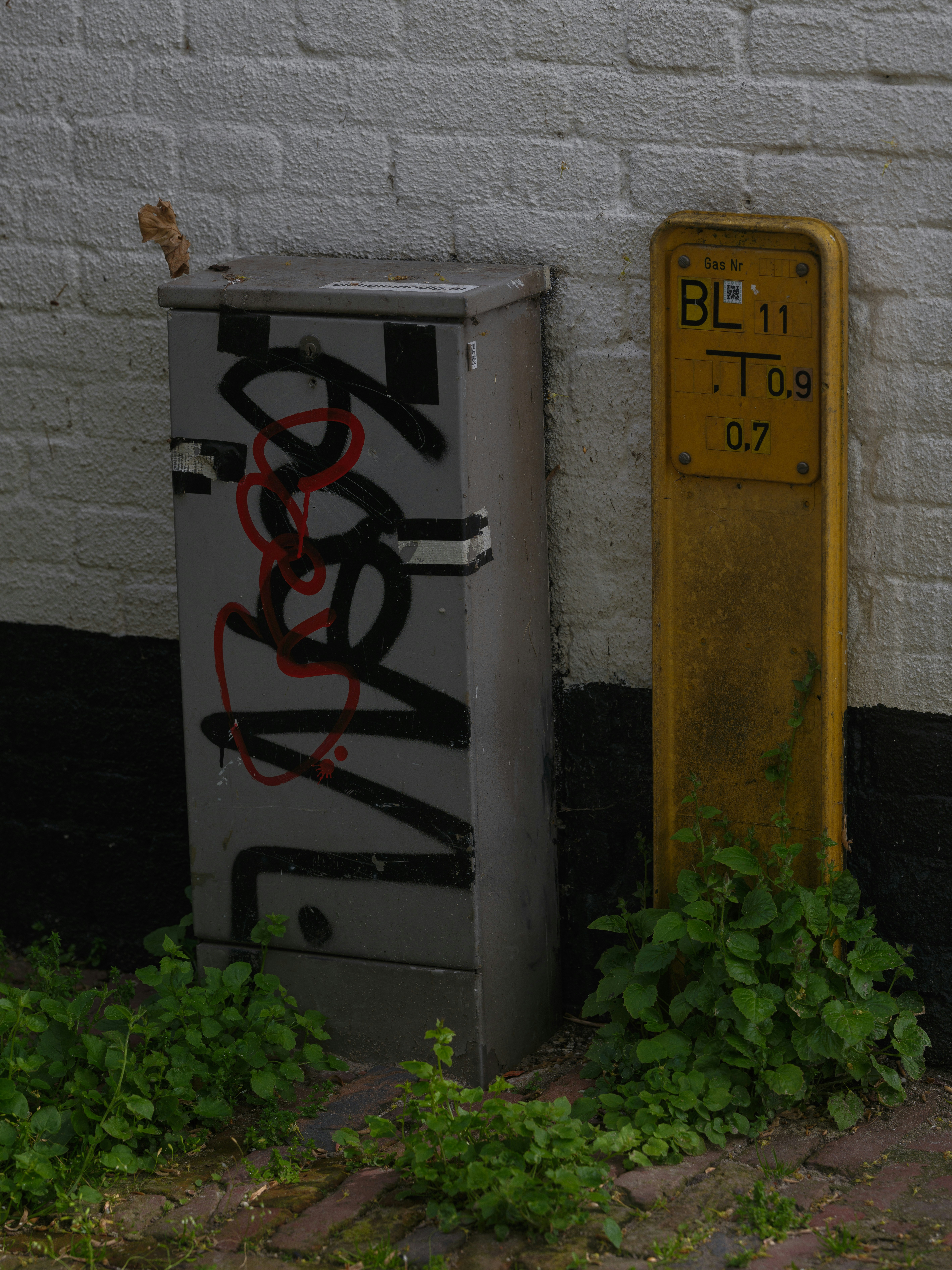 Urban Rust and Graffiti: A Quiet Corner Between Utility Boxes