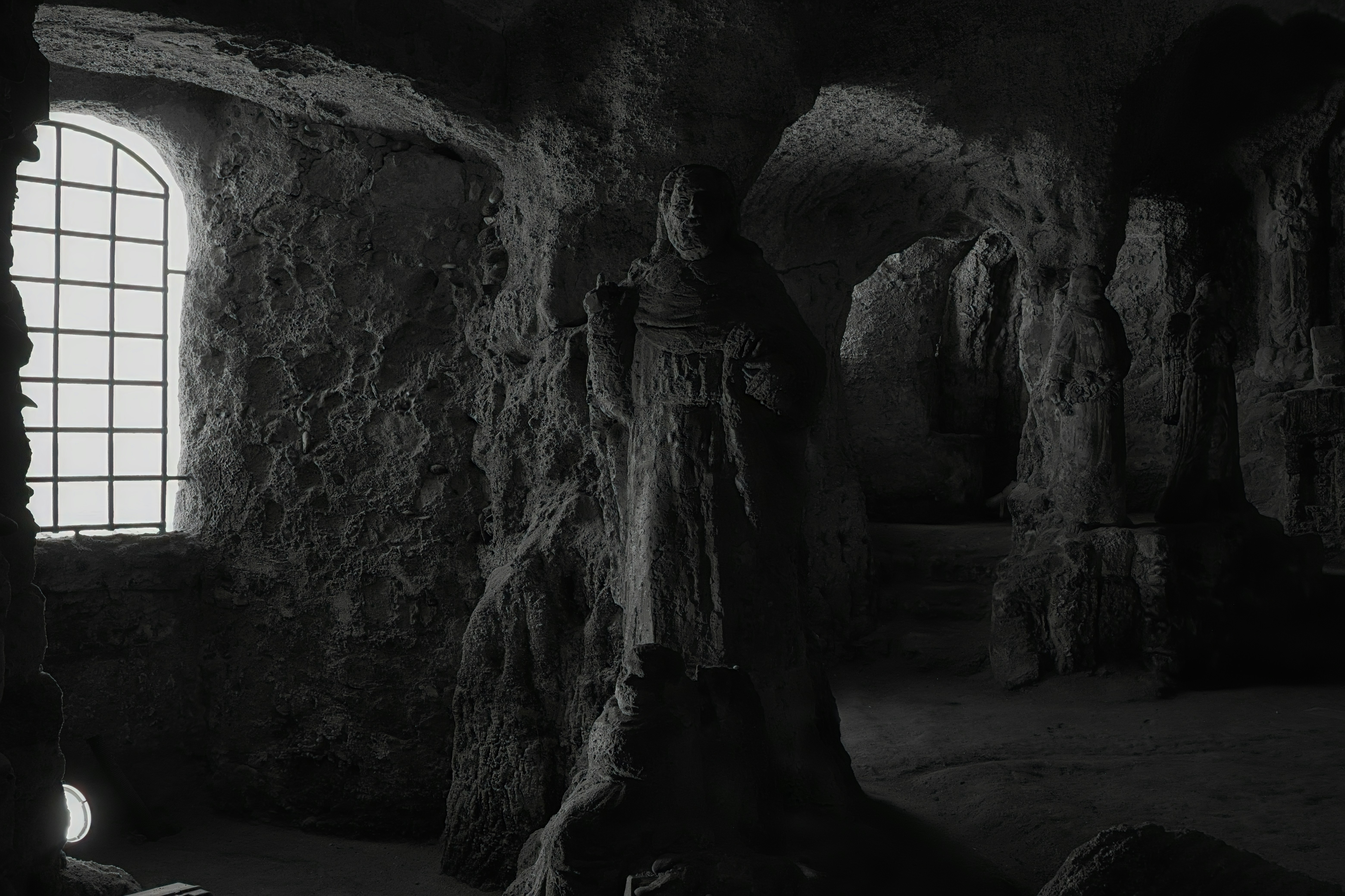 Shadowed Statue in a Stone Chapel