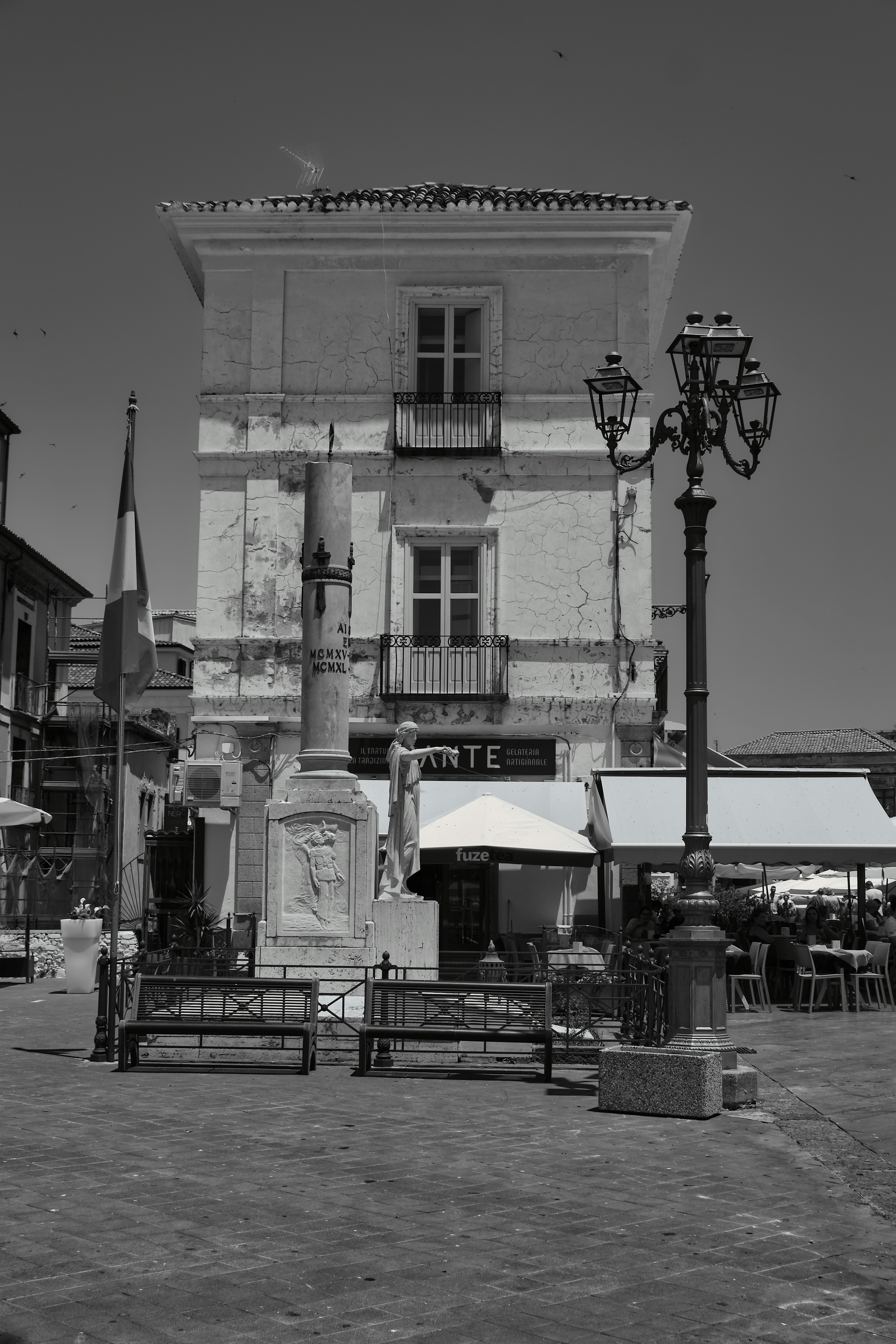 Stone Square: Lantern, Statue, and Café in Monochrome