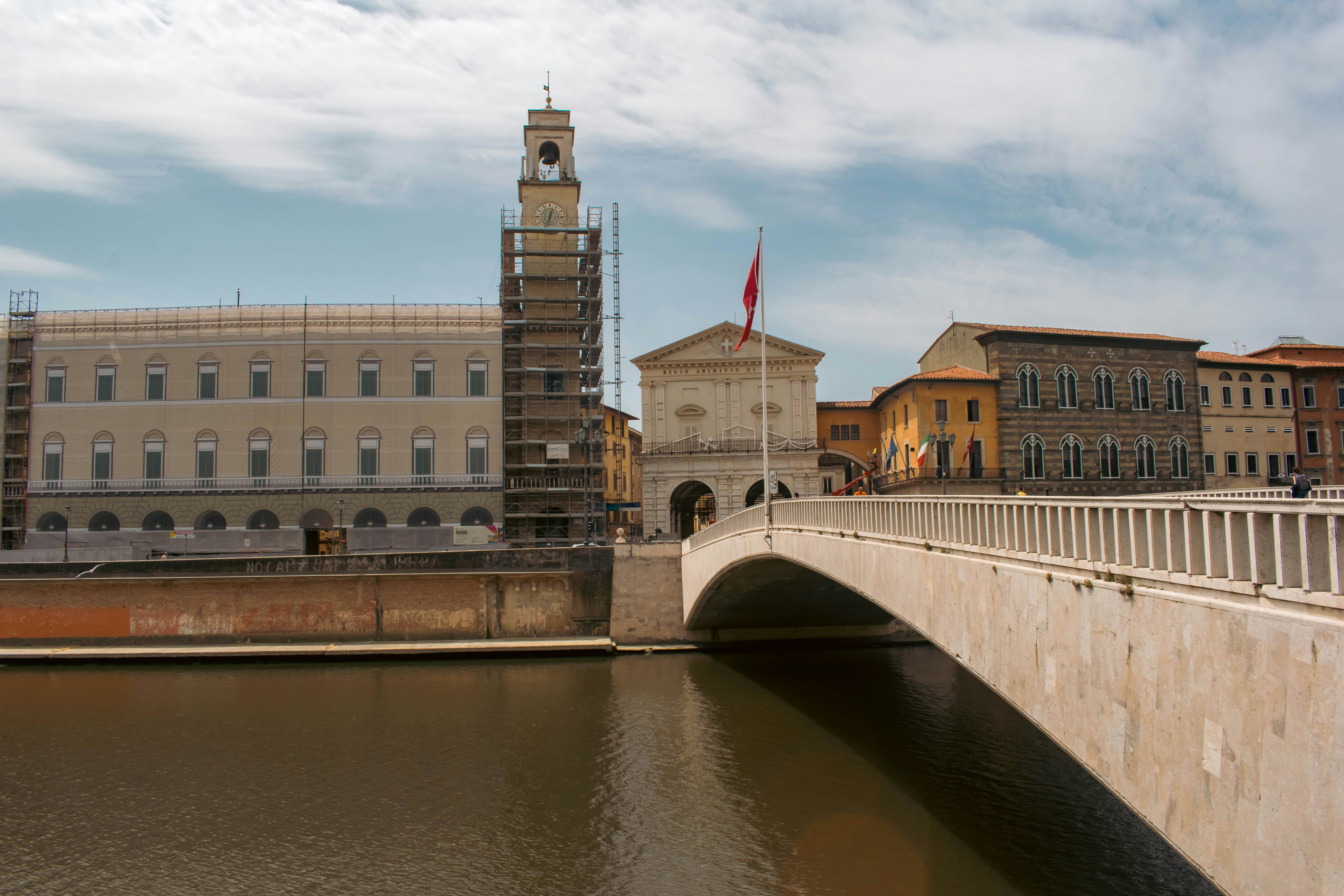 Historic Arched Bridge and Town Hall Under a Clear Sky
