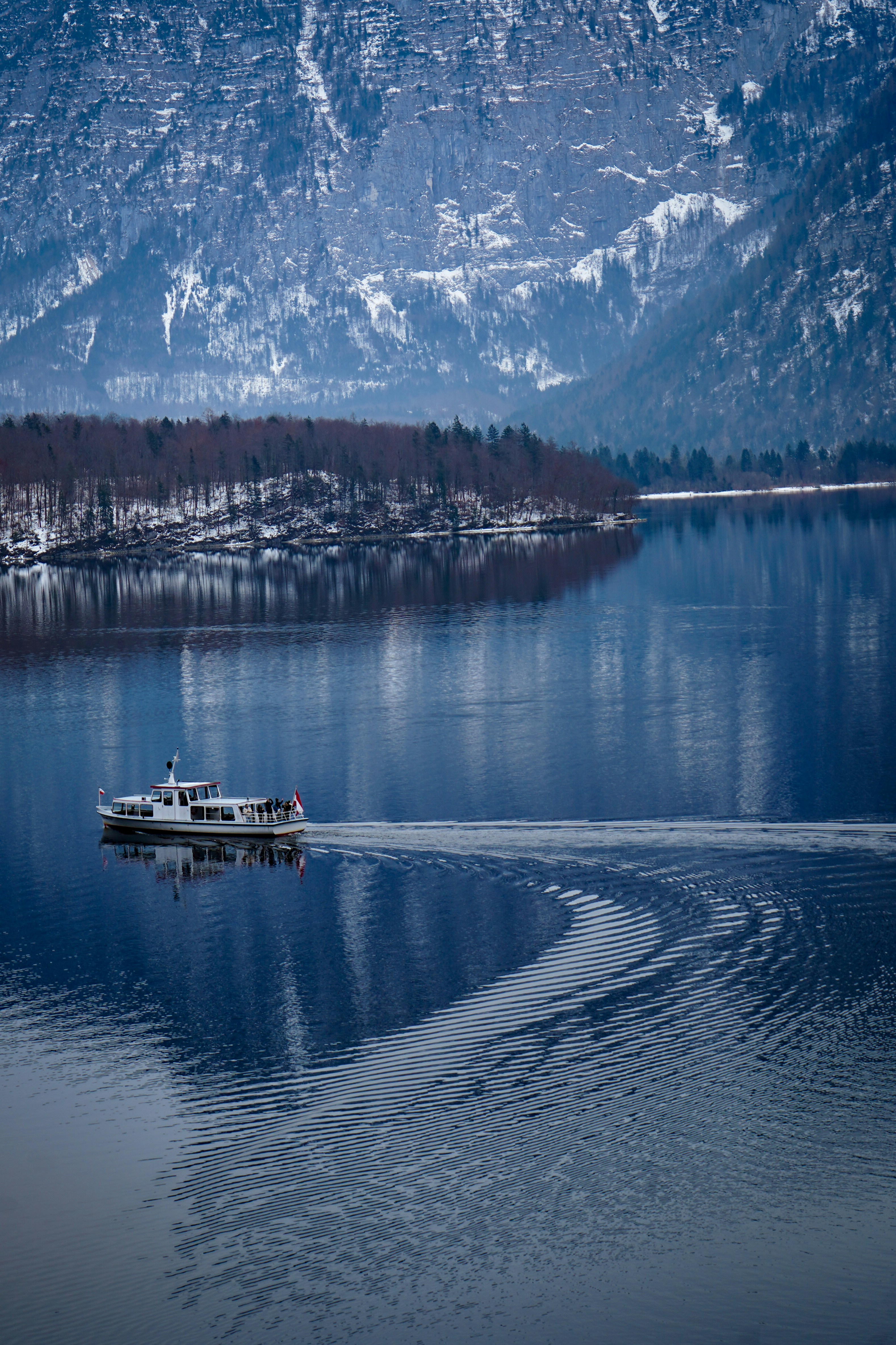 Boat on a Quiet Blue Fjord Under Snow-Capped Peaks