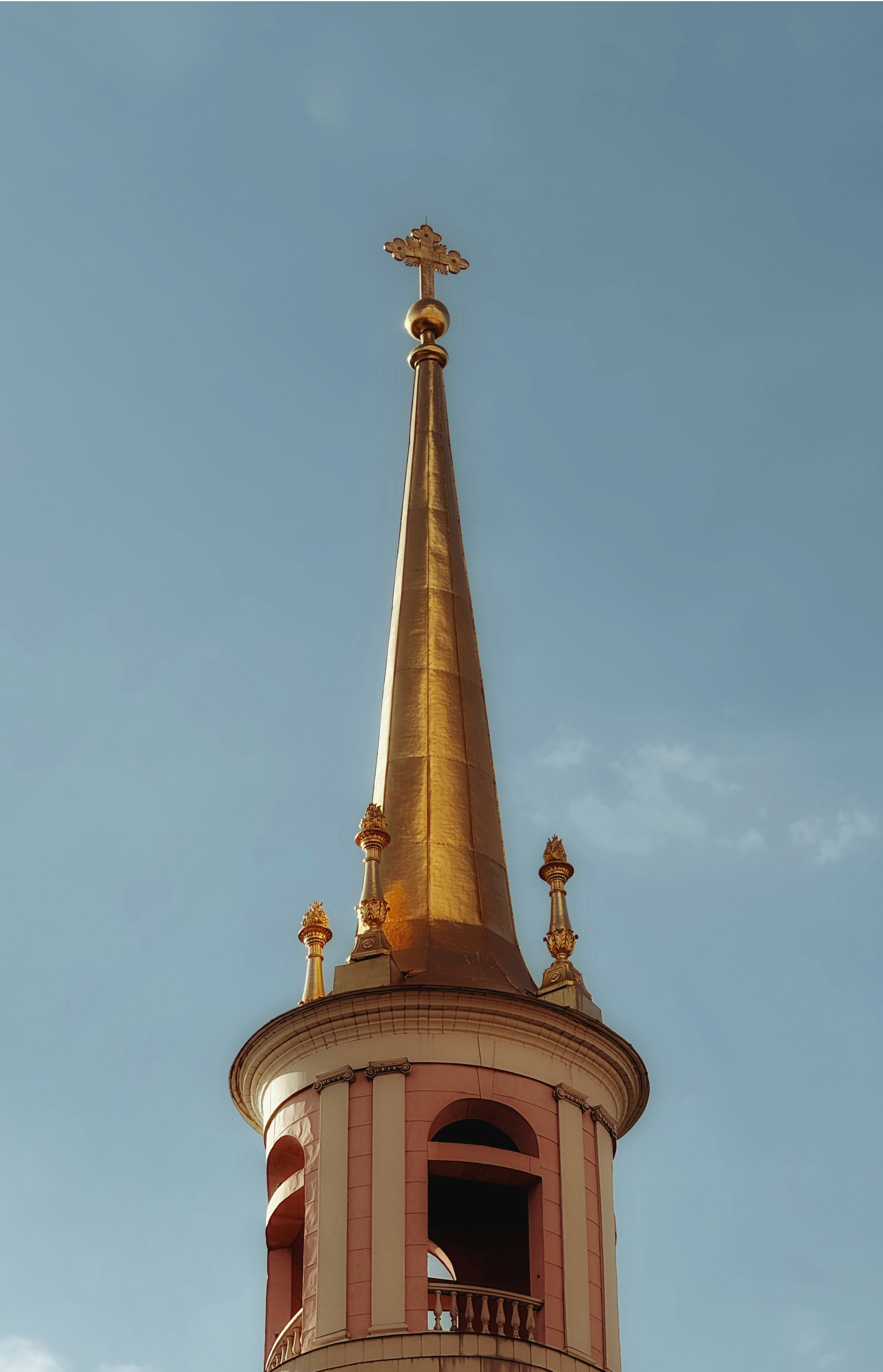 Golden spire of a church against a clear blue sky.