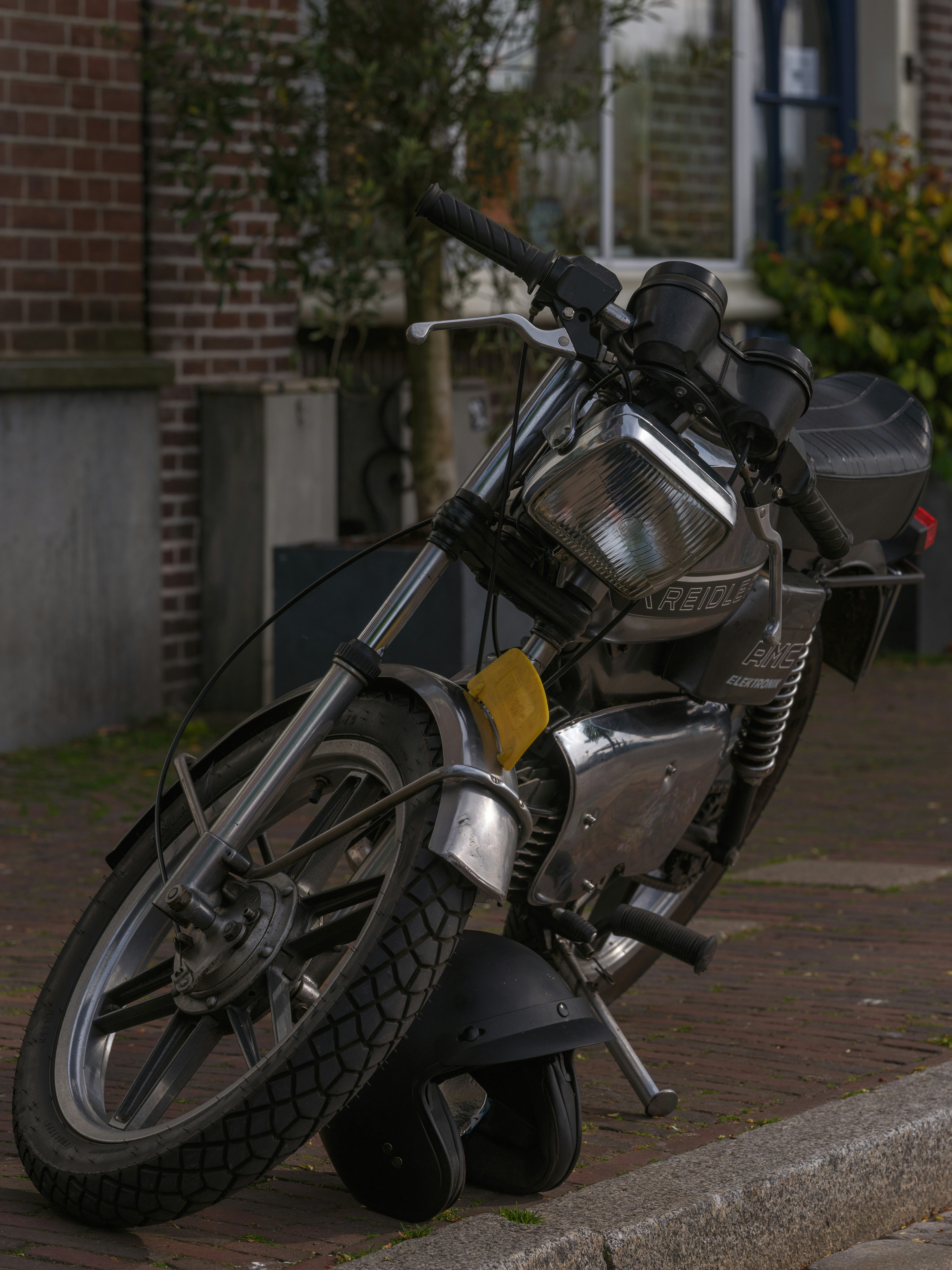 Weathered Triumph: A Tilted Street Warrior in Quiet Red Brick