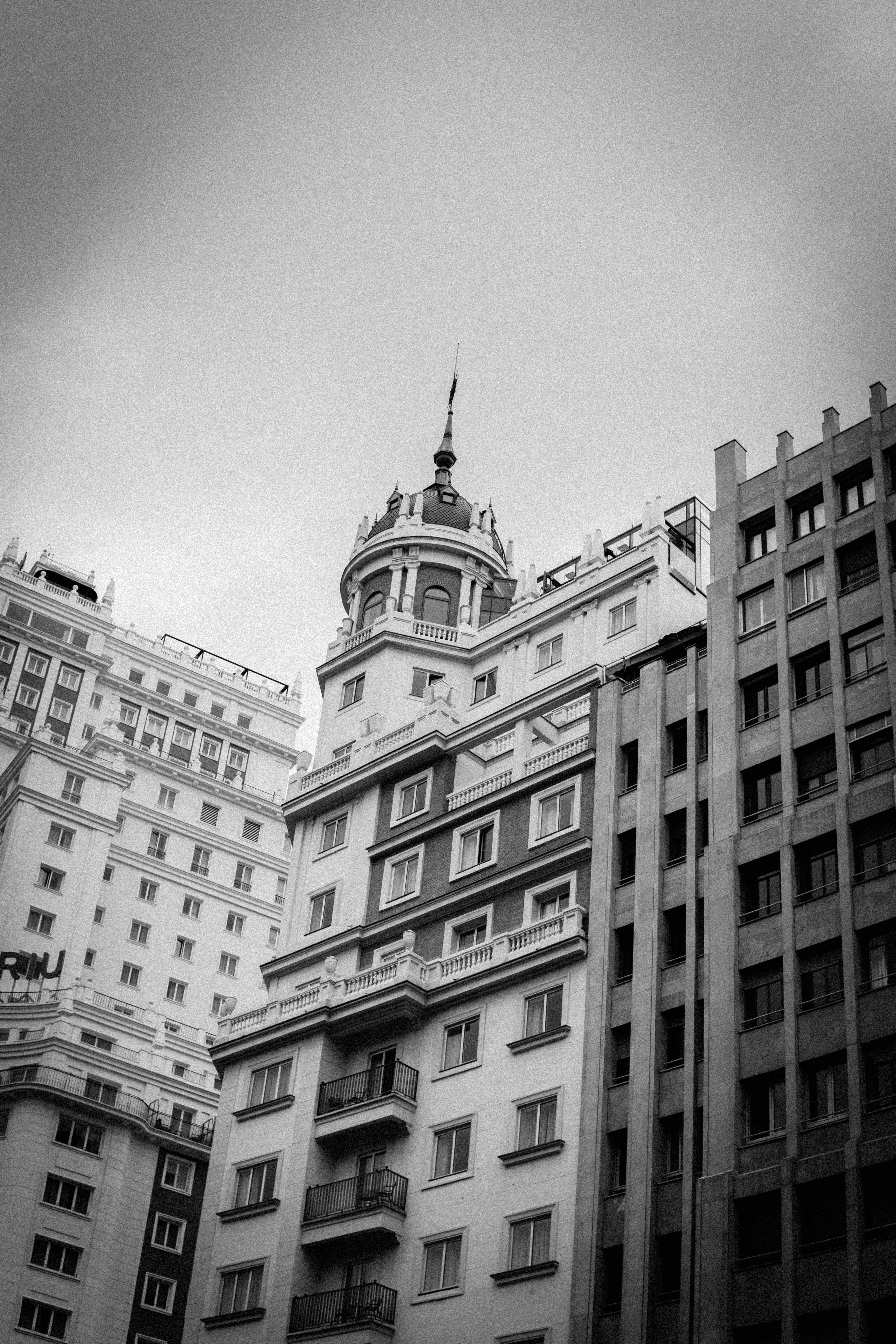 Monochrome view of urban buildings with a prominent domed rooftop.