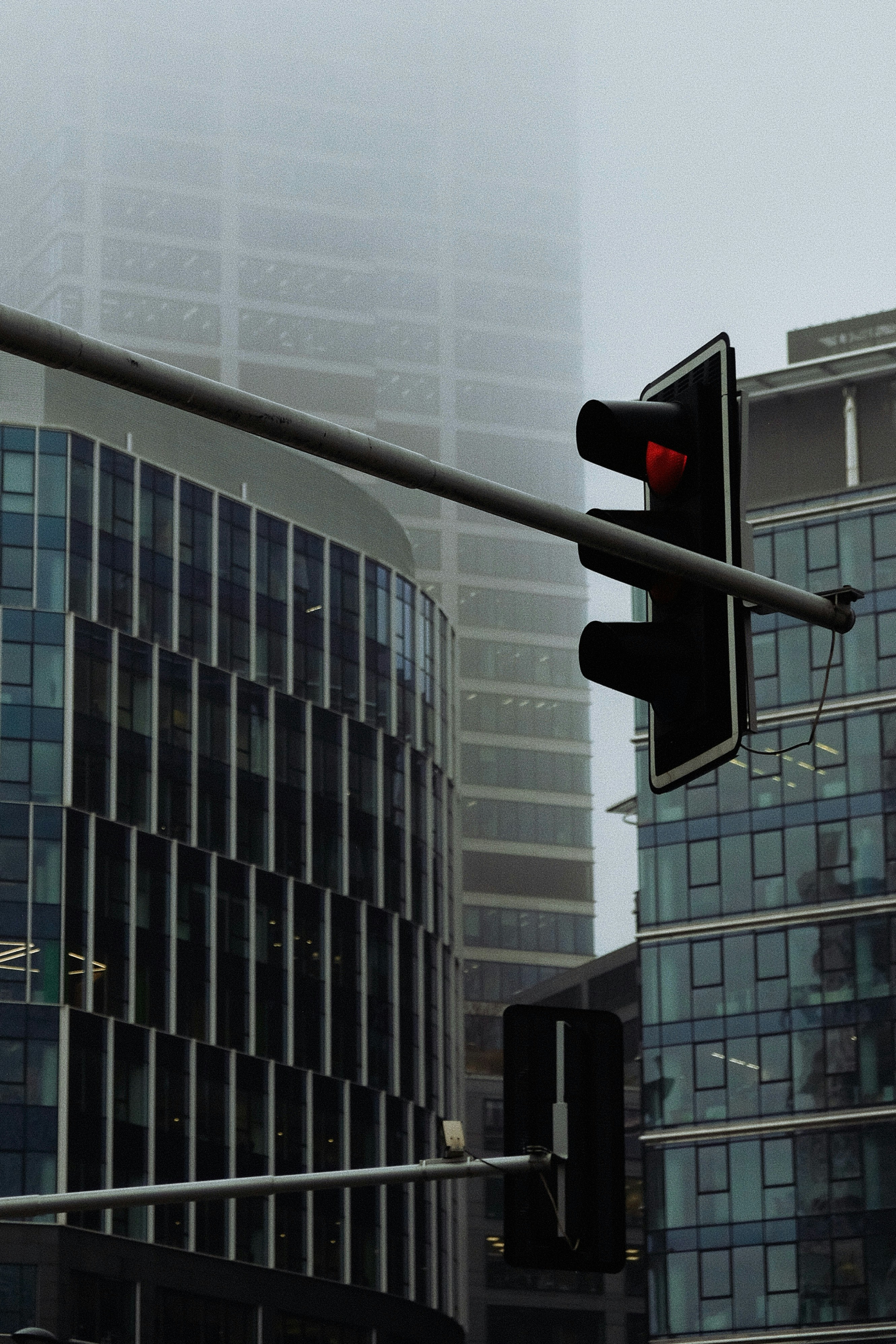 Red Signal in a Hazy City: A Quiet Crossing Under Glass Skies