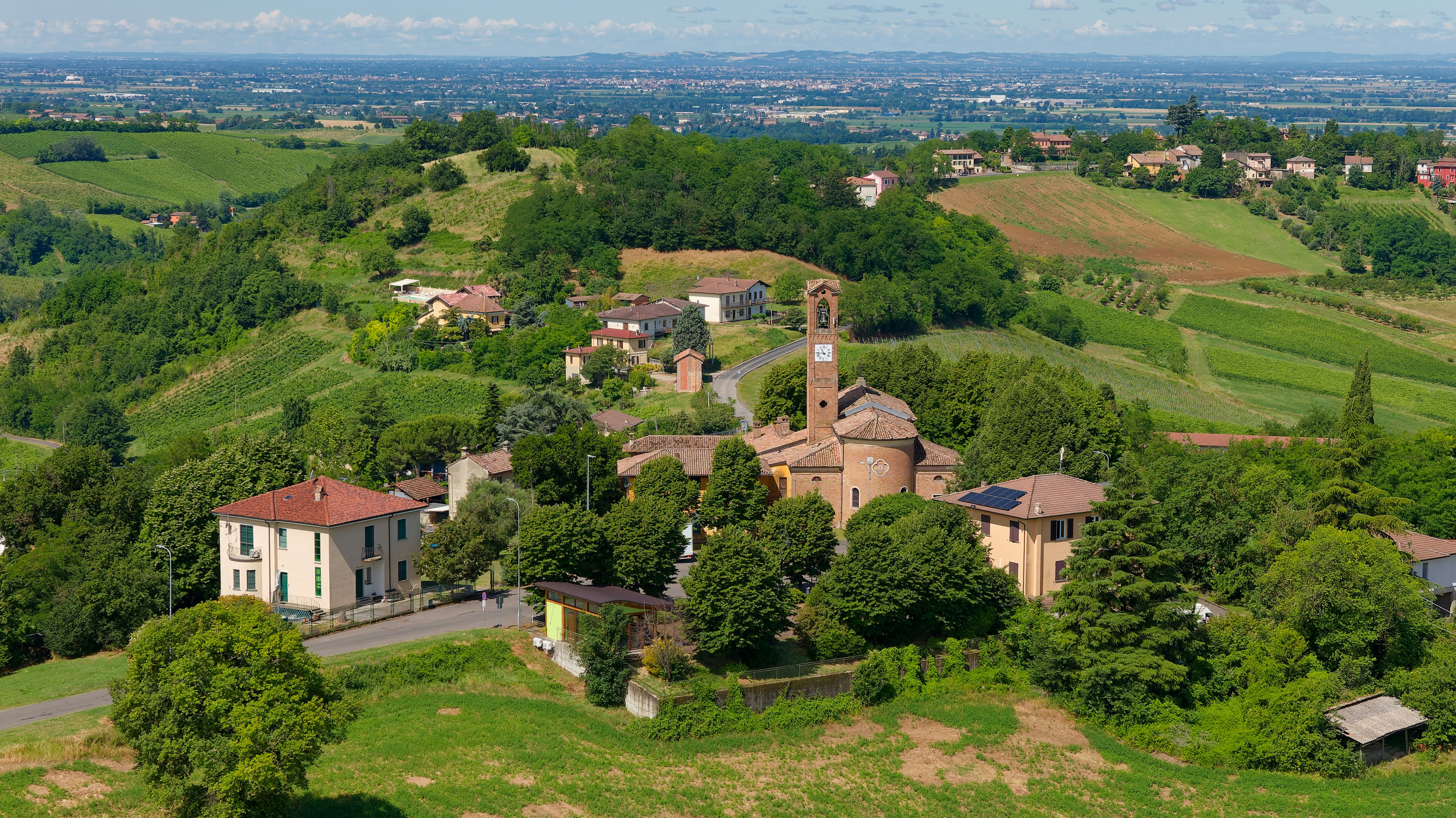 Hilltop Village with Clock Tower Amid Rolling Greenery