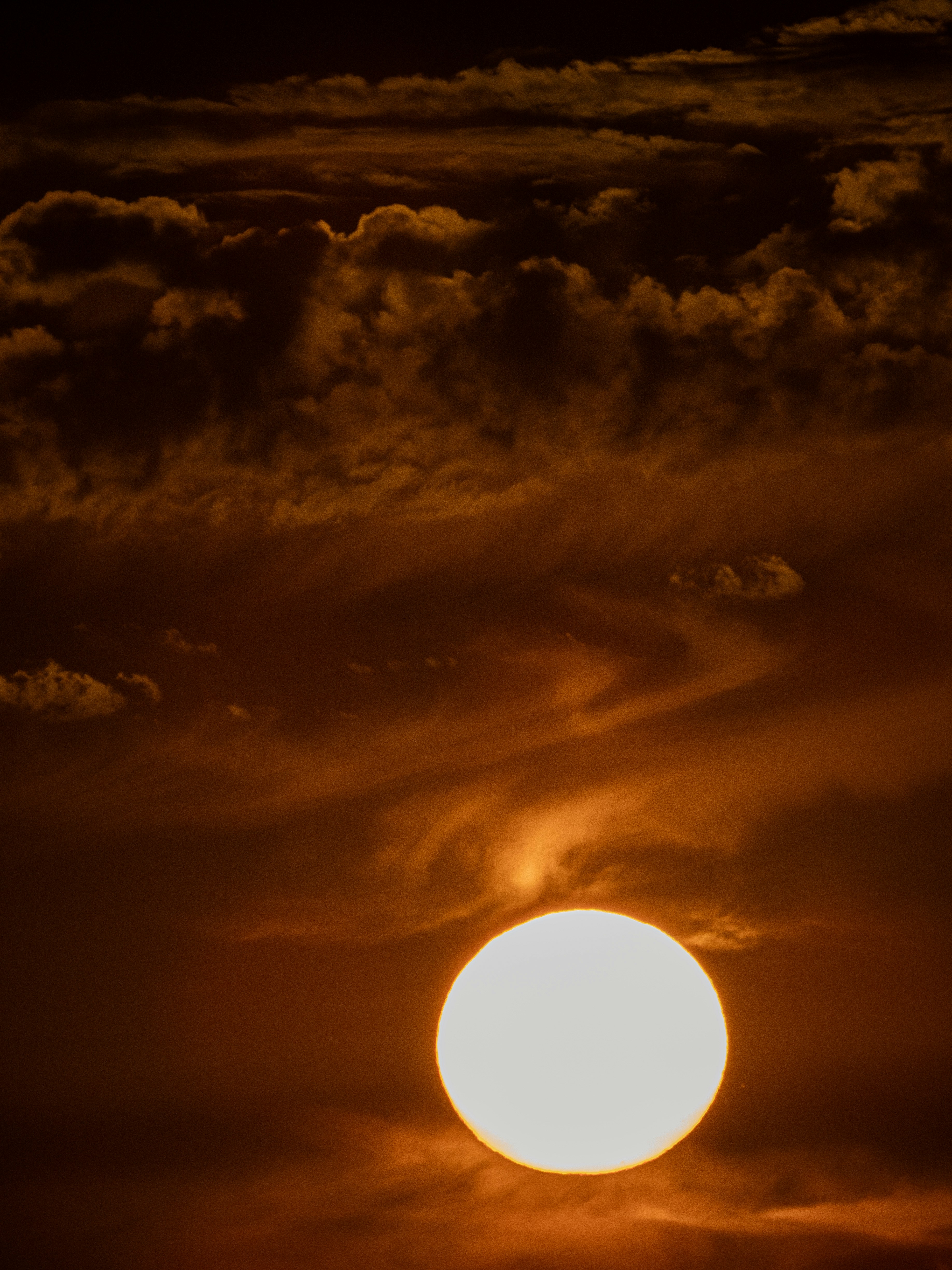 Solar Monolith: A Golden Sun at the Edge of Clouds