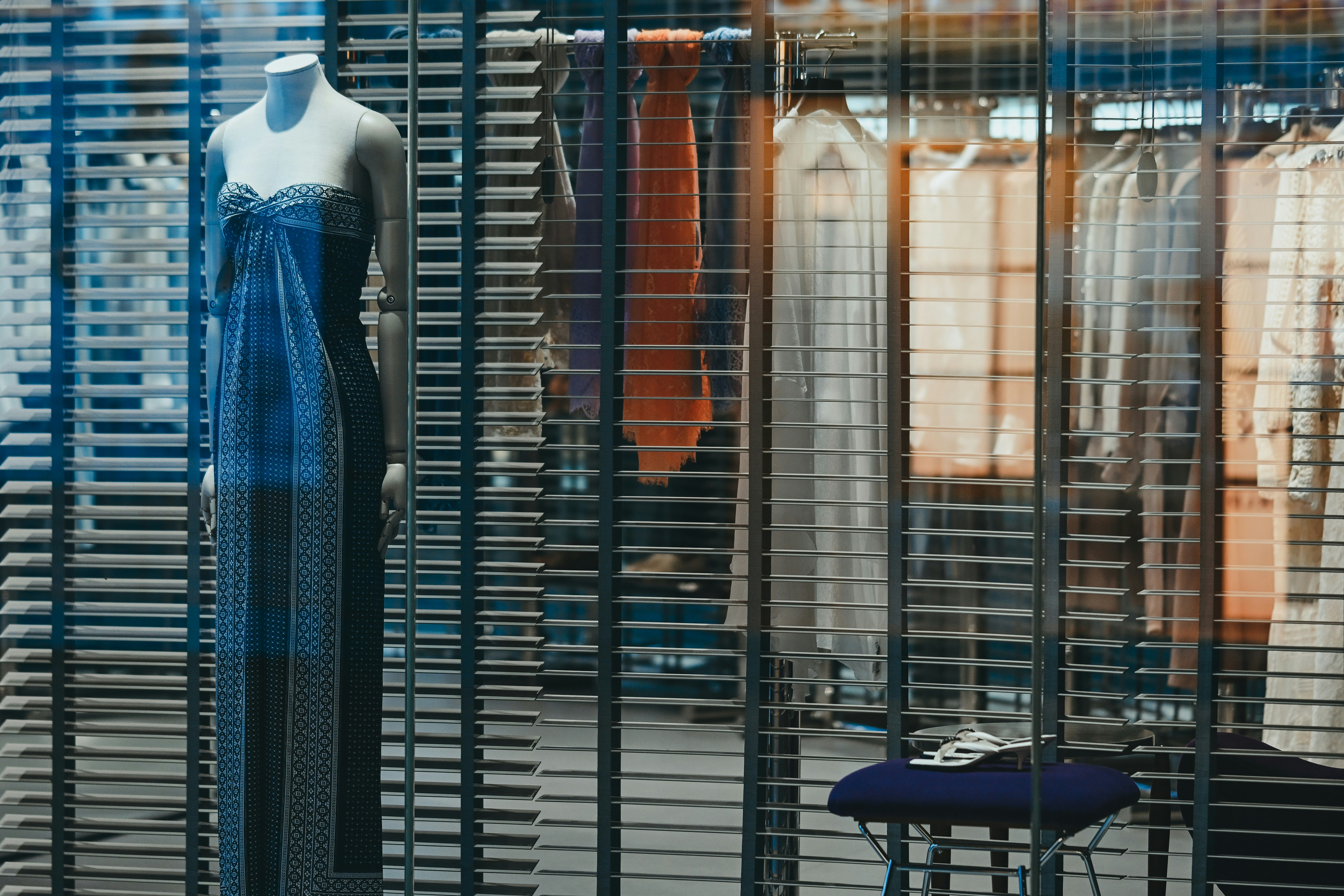 Blue Strapless Gown Standing Behind Slatted Glass
