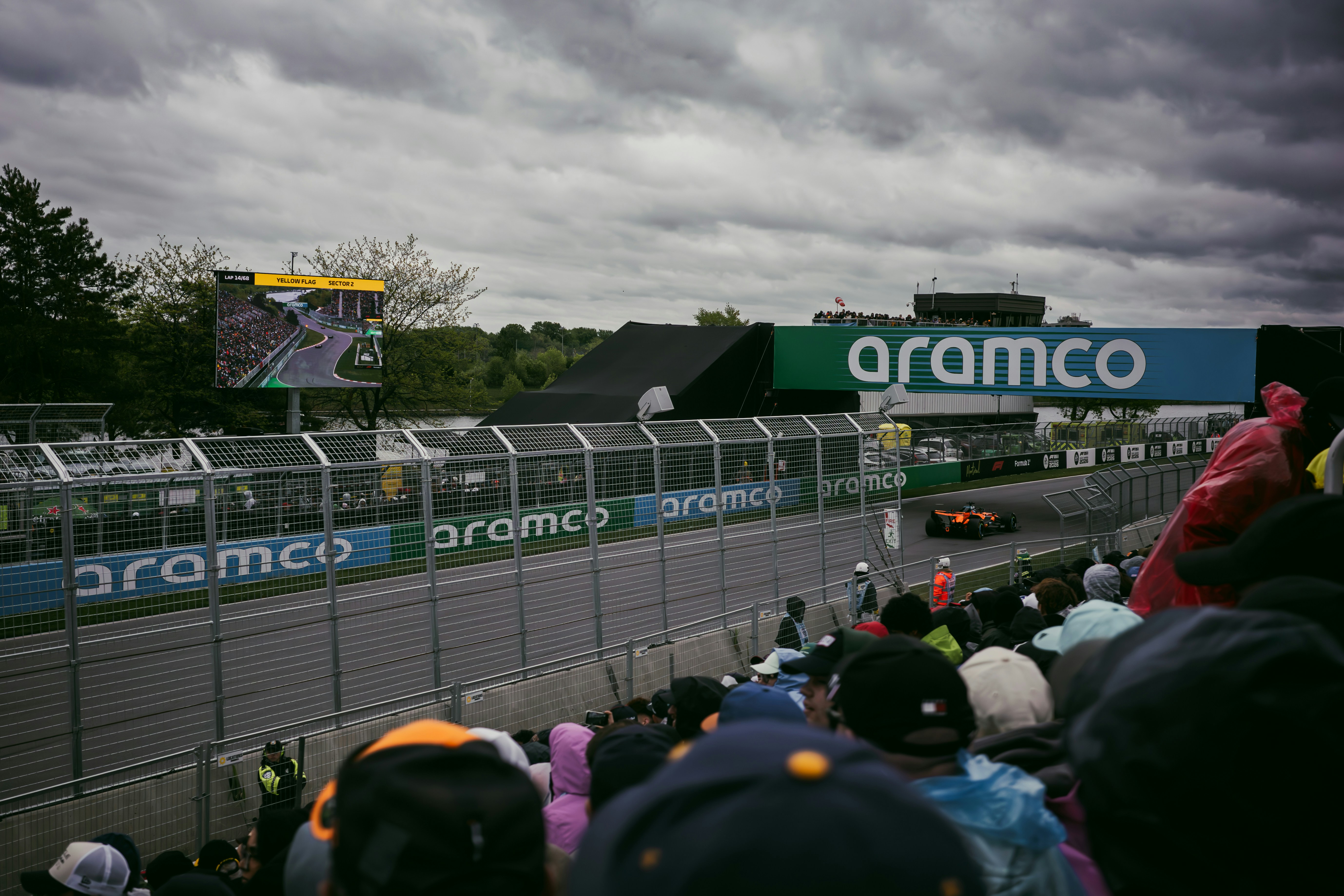 Finish Line Rush: Gripped Crowd and the Lead Car at the Circuit
