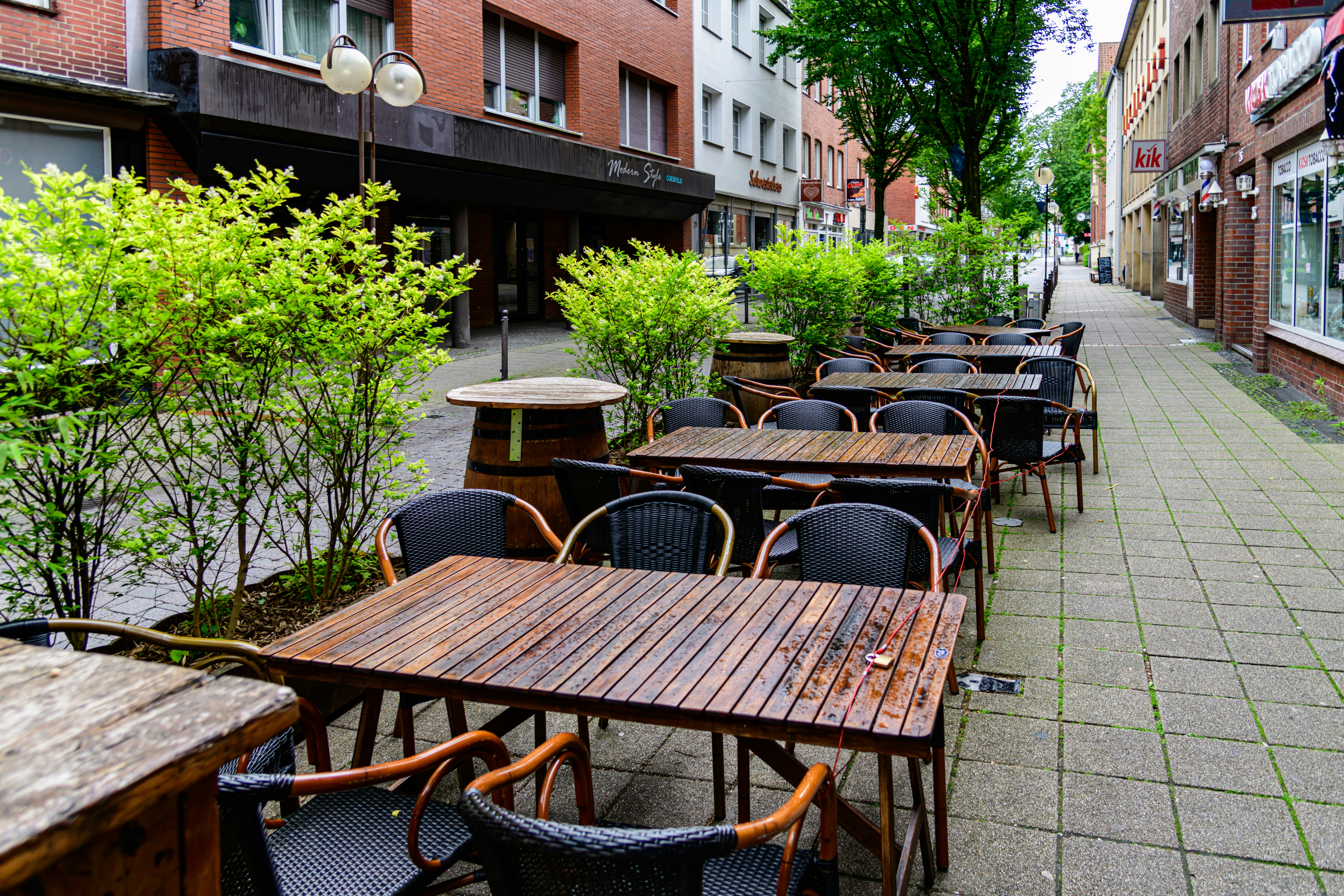 Row of Weathered Café Tables: Vanishing Street Down the City Walk