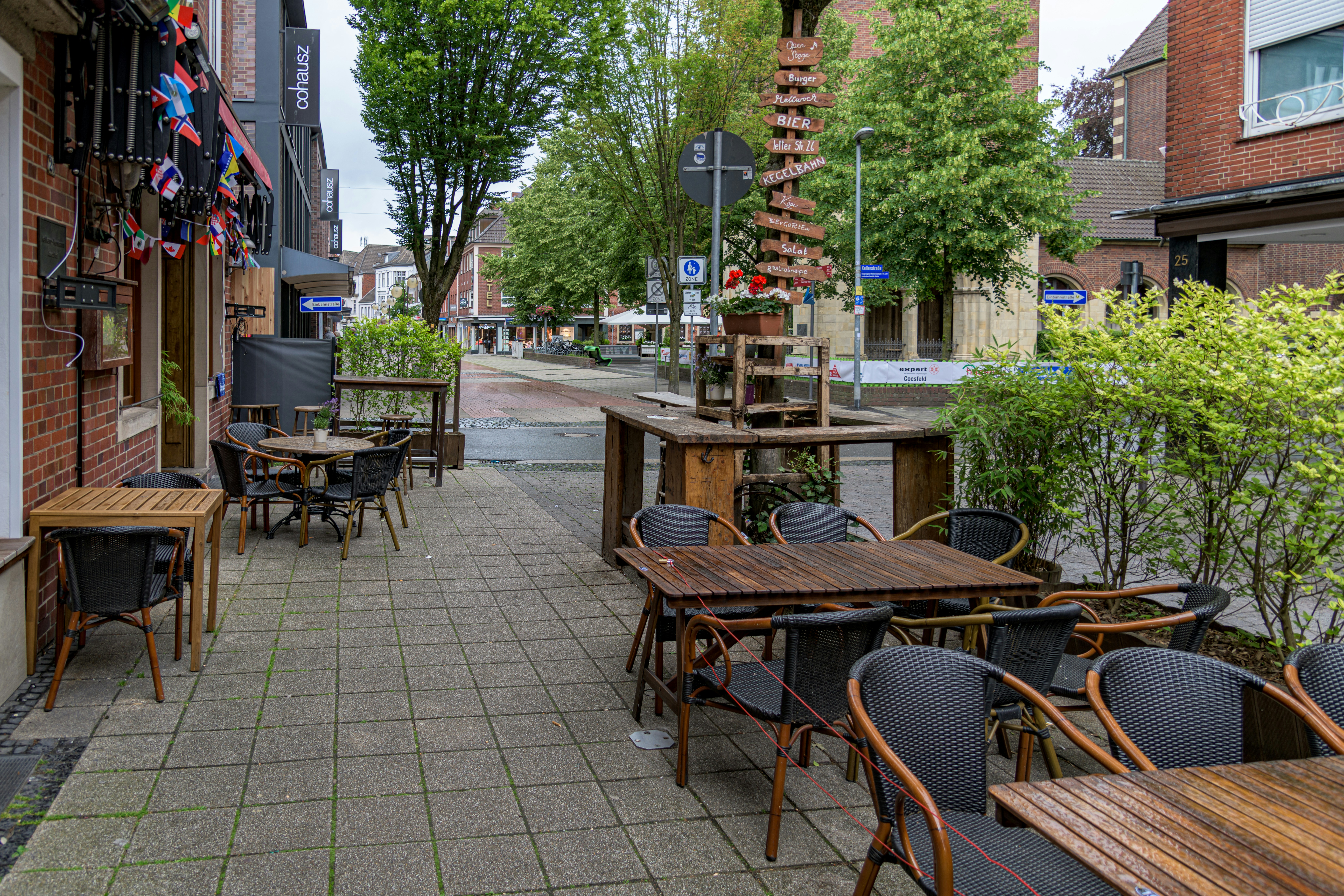 Quiet Courtyard Café Alley: Wooden Tables Framing a City Street