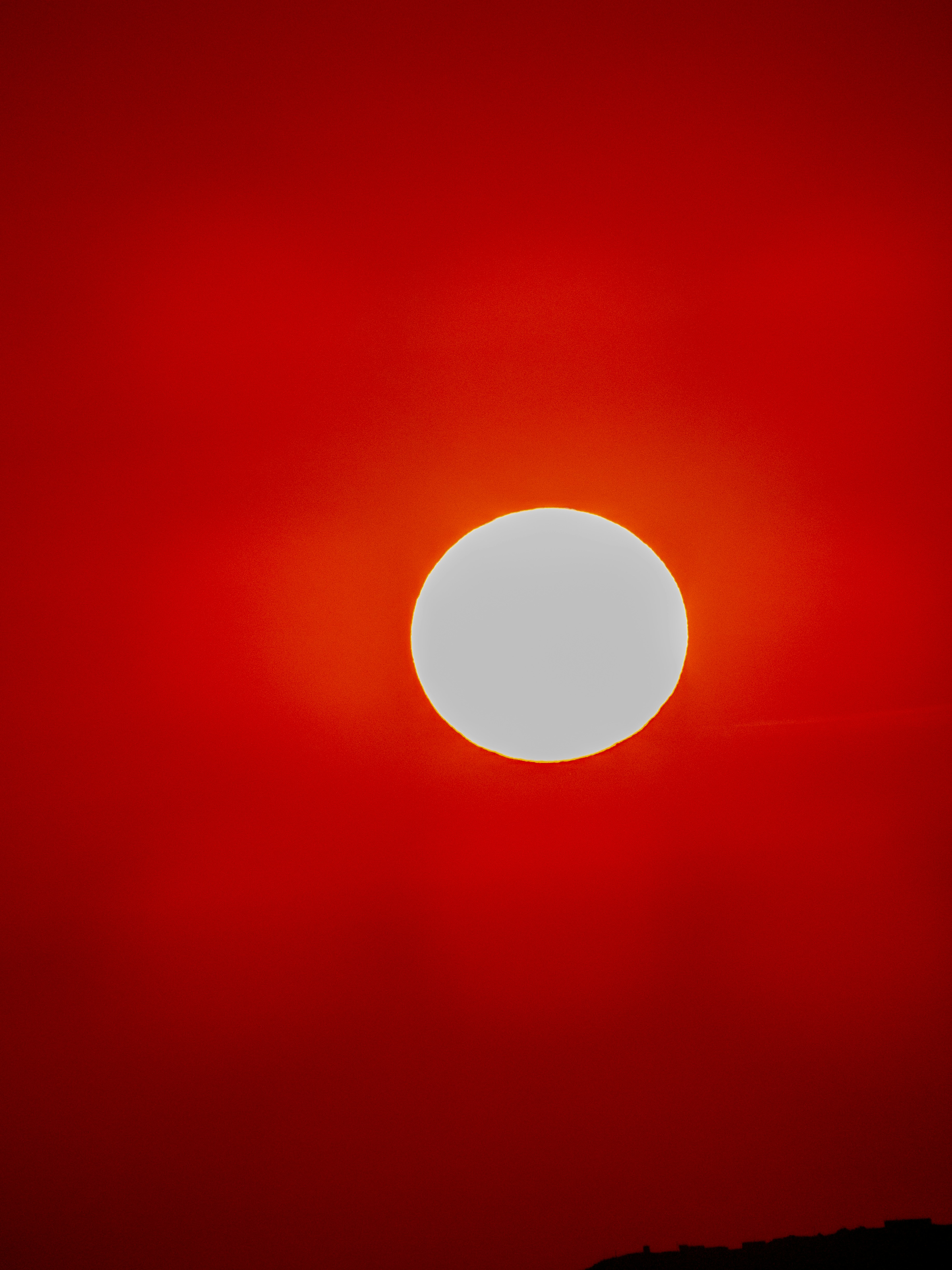 Crimson Sun over a Quiet Horizon