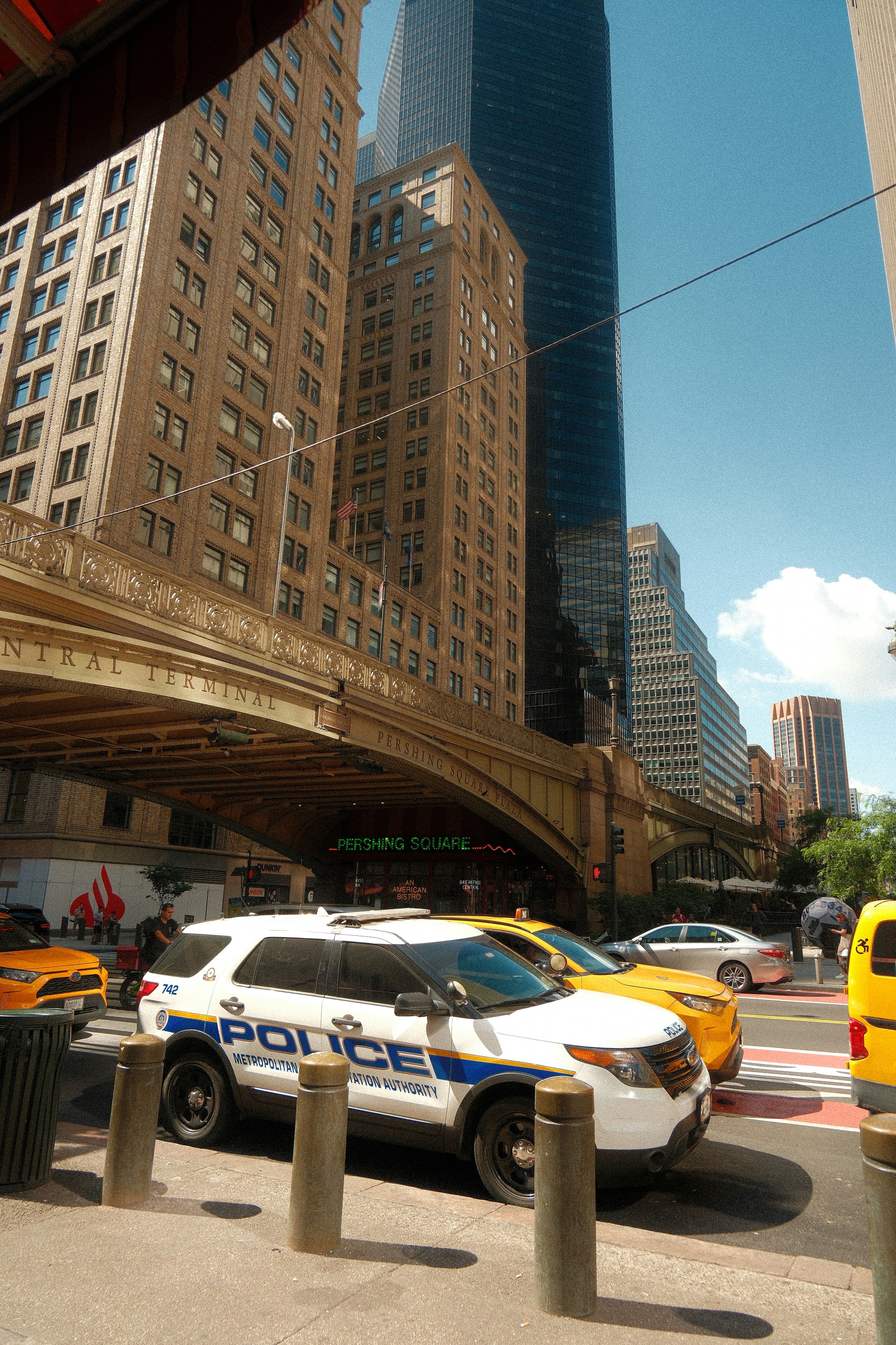Police suv and yellow cabs on a busy city street.