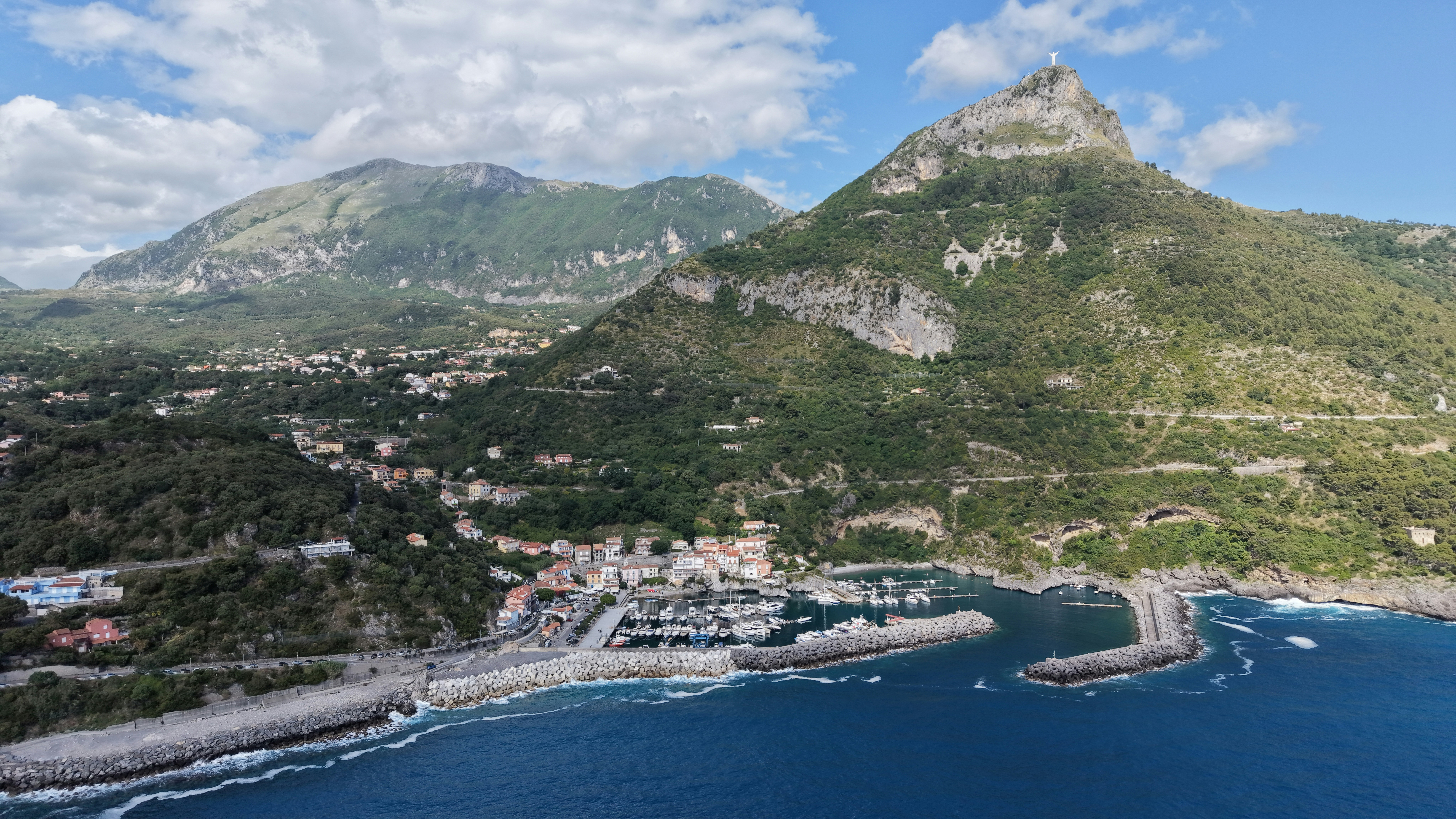 Coastal village pressed against fortress-like cliffs