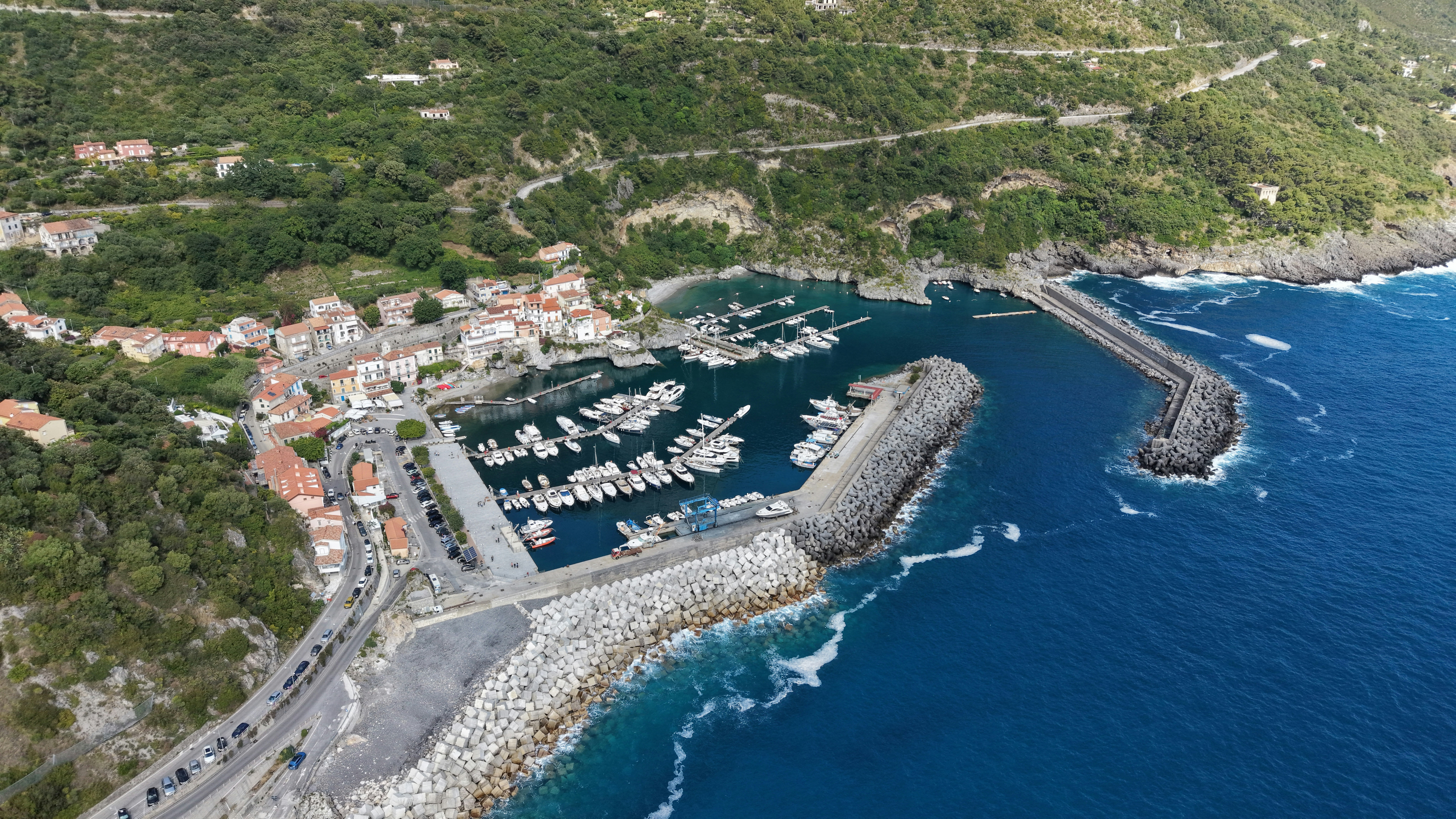 Harbor Ribbon: Boats, Breakwater, and Cliffside Village