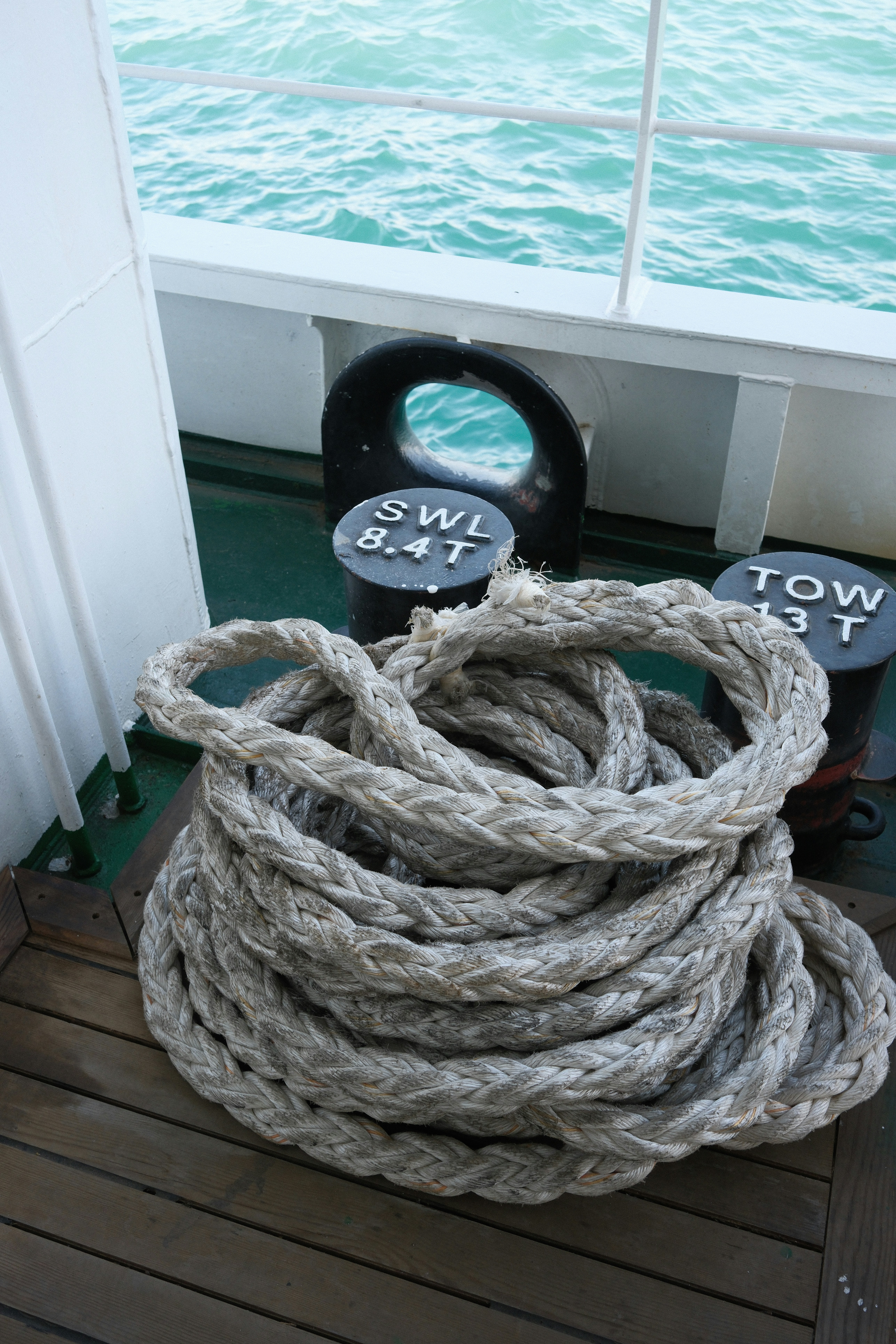 Coiled rope on a ship's deck with ocean in background.