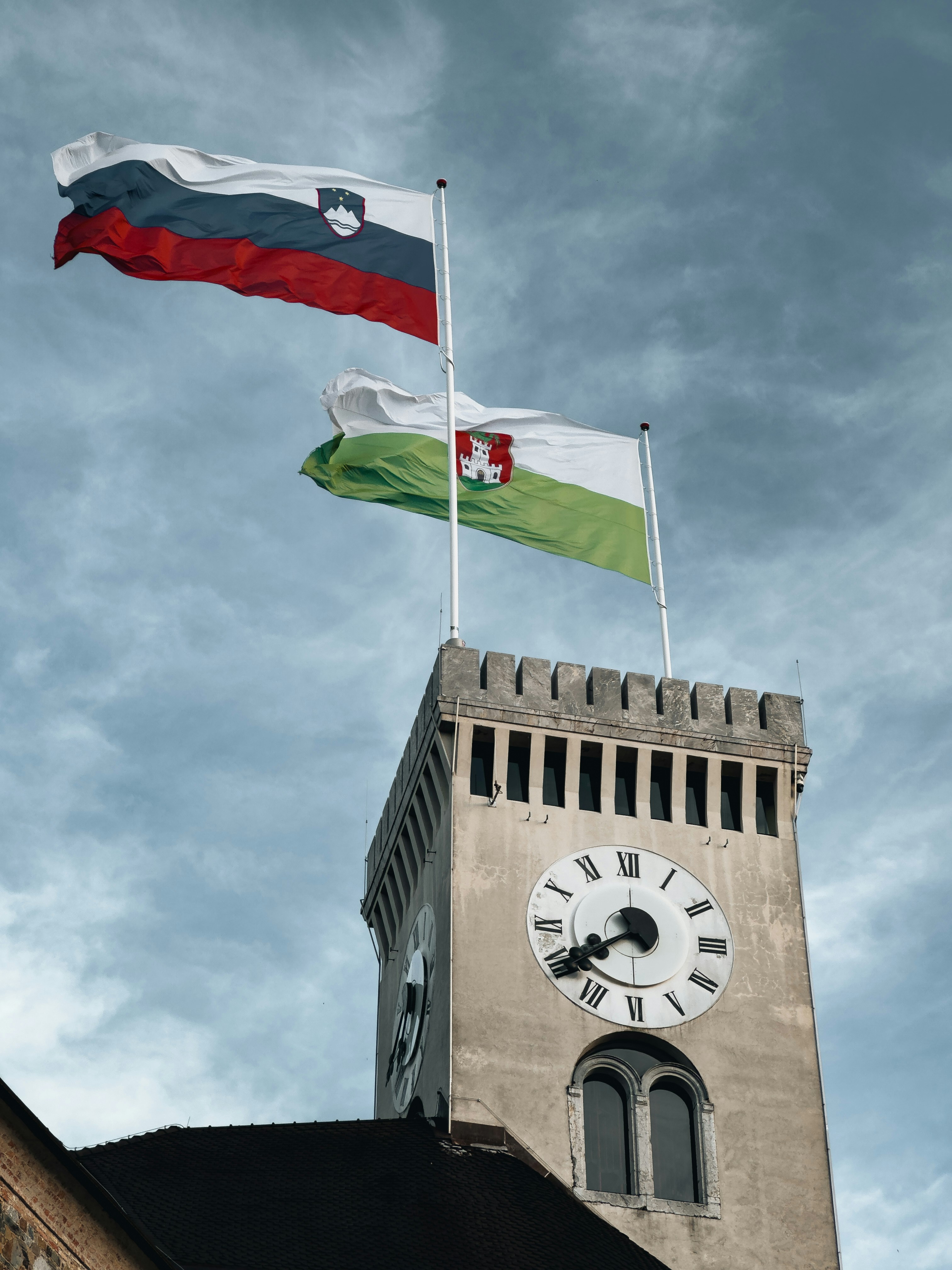 Flag Towers and Clock Face: A Timeless View Above the Rooftops