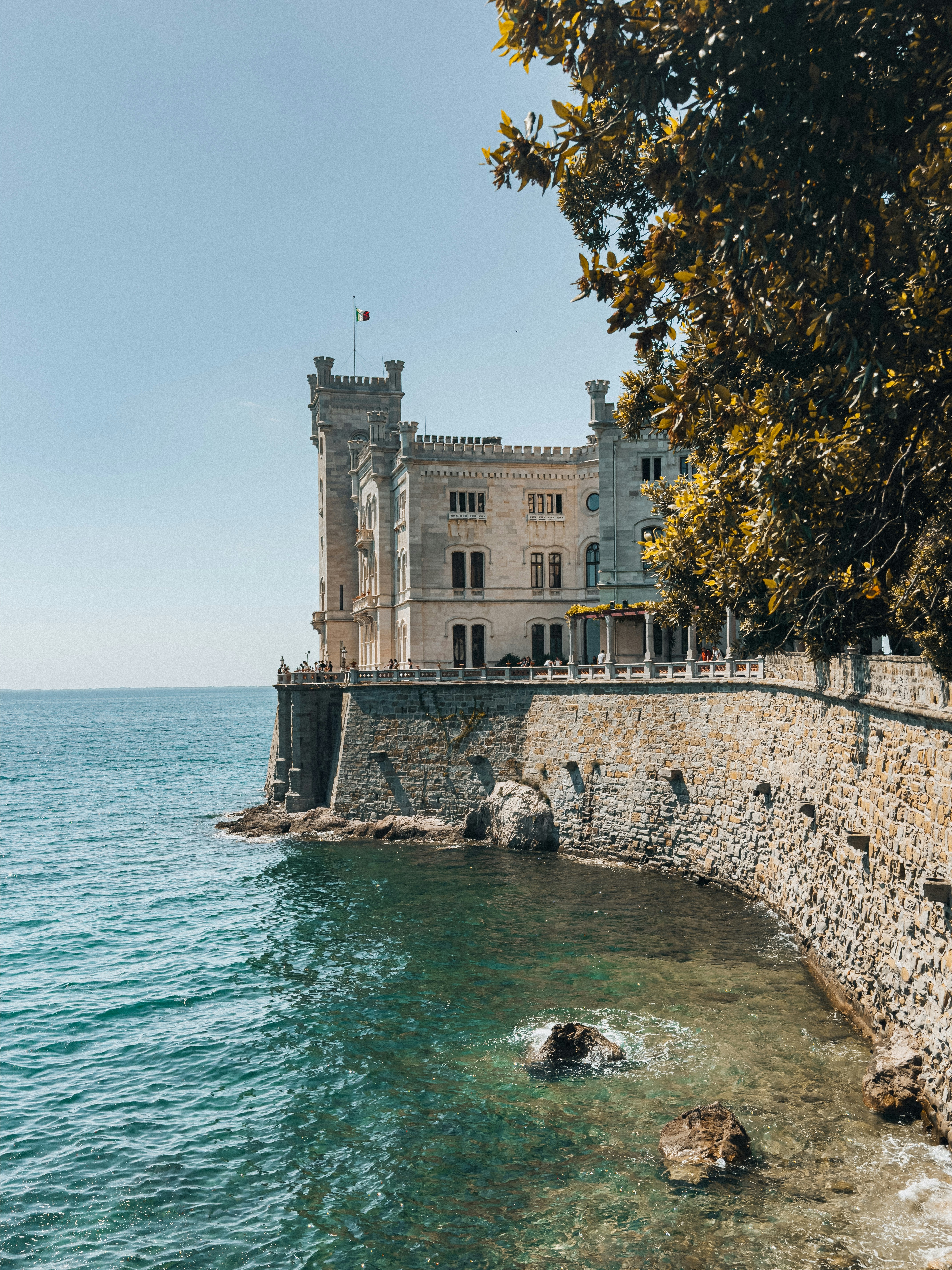 The stunning Miramare Castle overlooking the Adriatic Sea near Trieste, Italy. A historic seaside palace surrounded by crystal-clear water, Mediterranean architecture, and breathtaking coastal scenery.