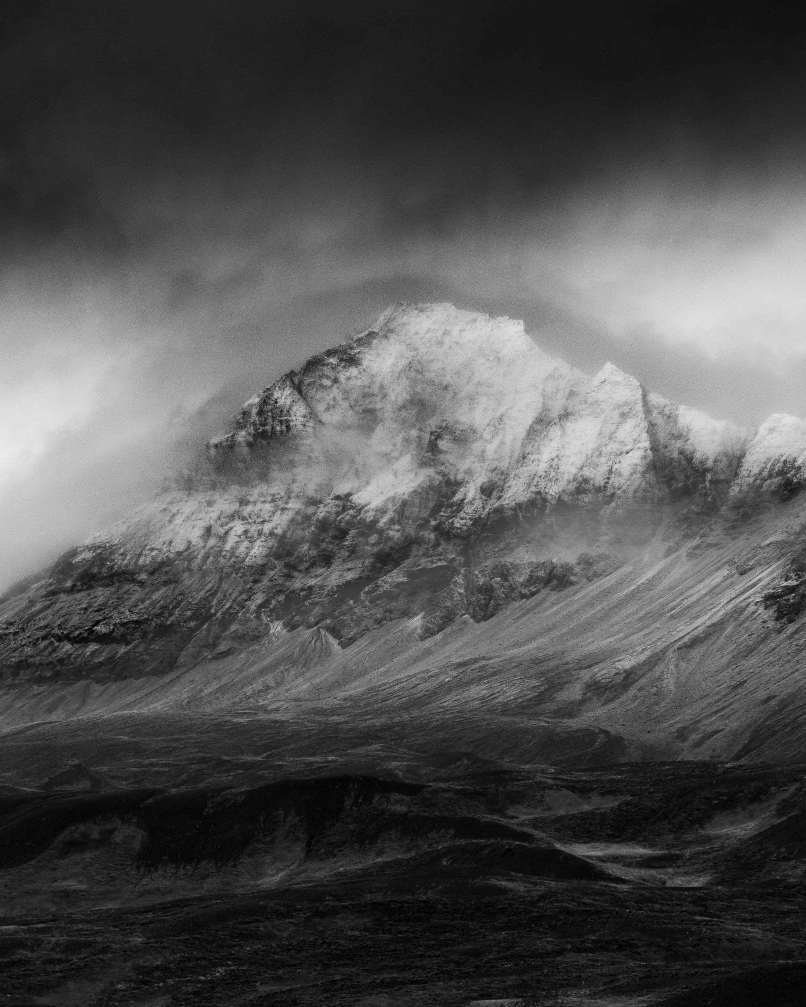 Snow-Crowned Peak Piercing through a Veil of Clouds