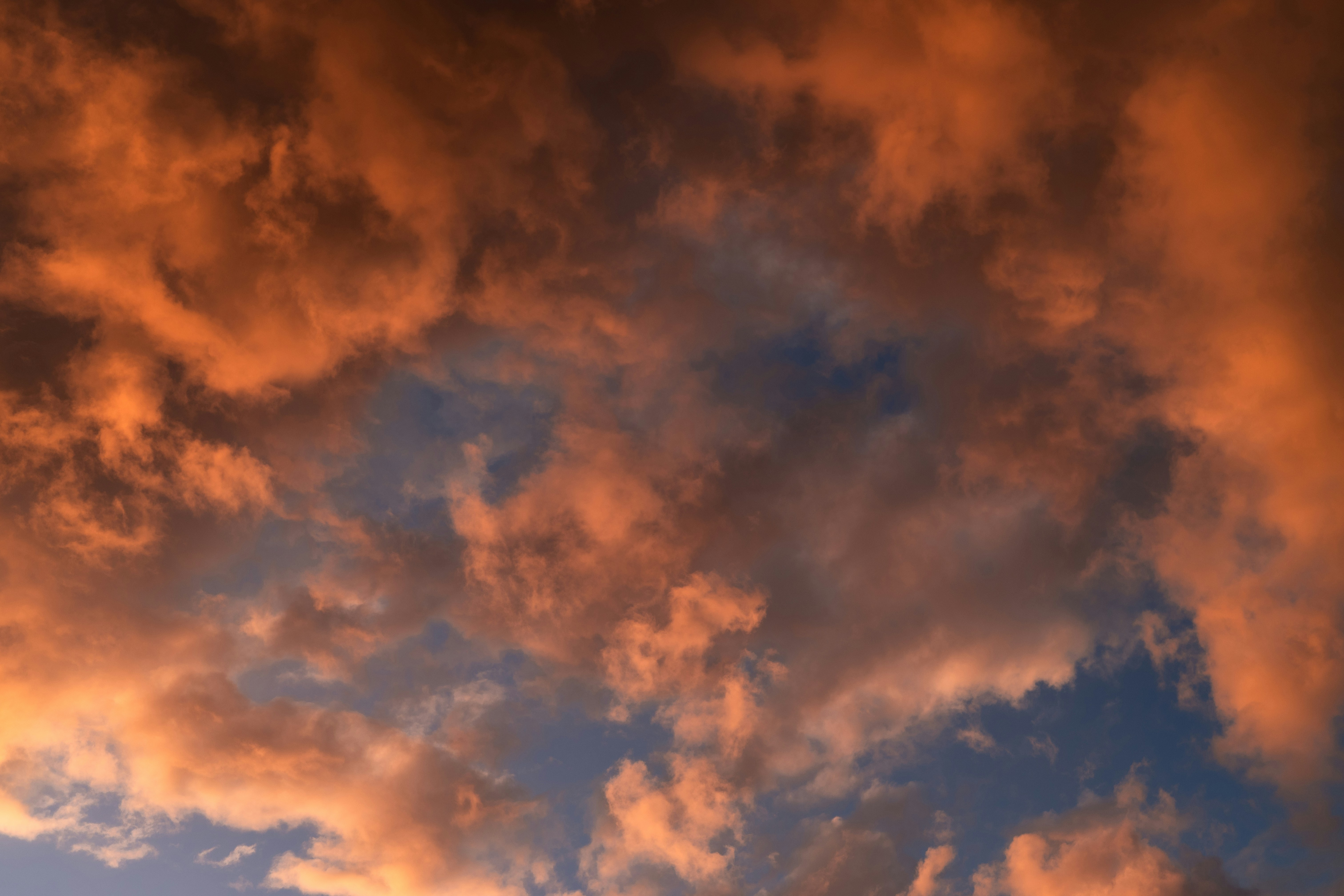 Dramatic orange and dark clouds fill the sky at sunset.