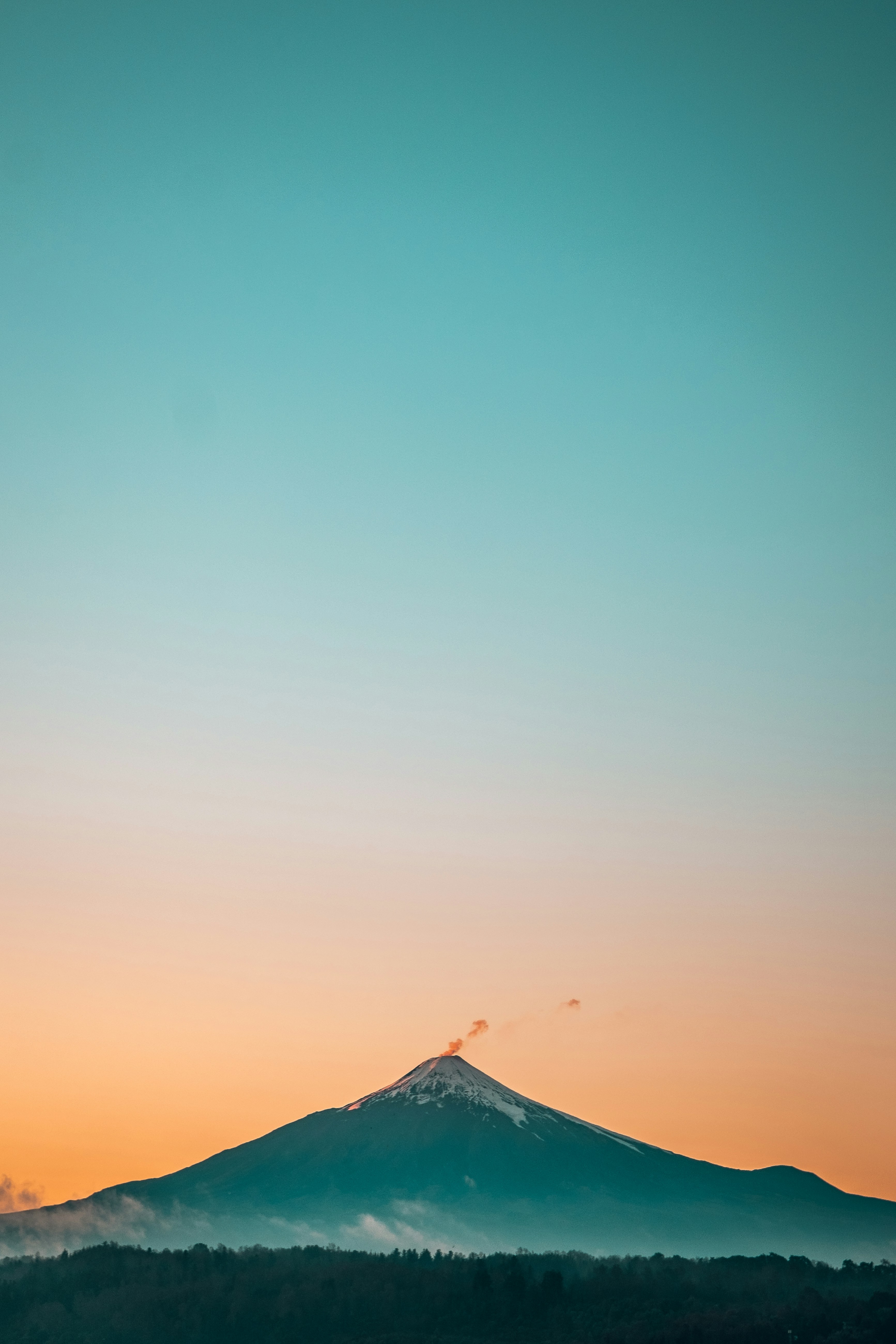 A majestic mountain peak against a vibrant sunset sky.
