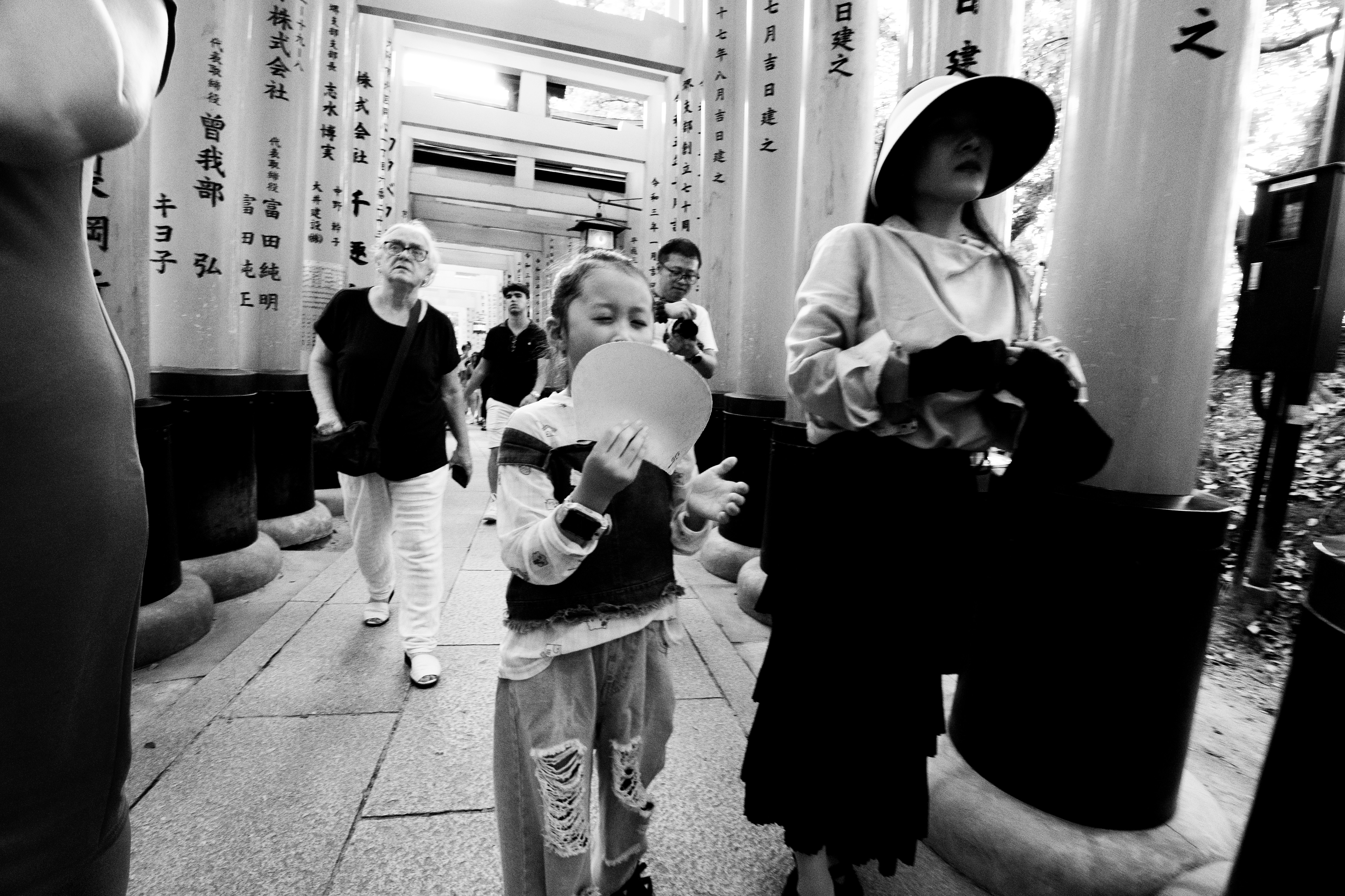 Crowd Quietly Surges Past a Shaded Bell-Tower Corridor
