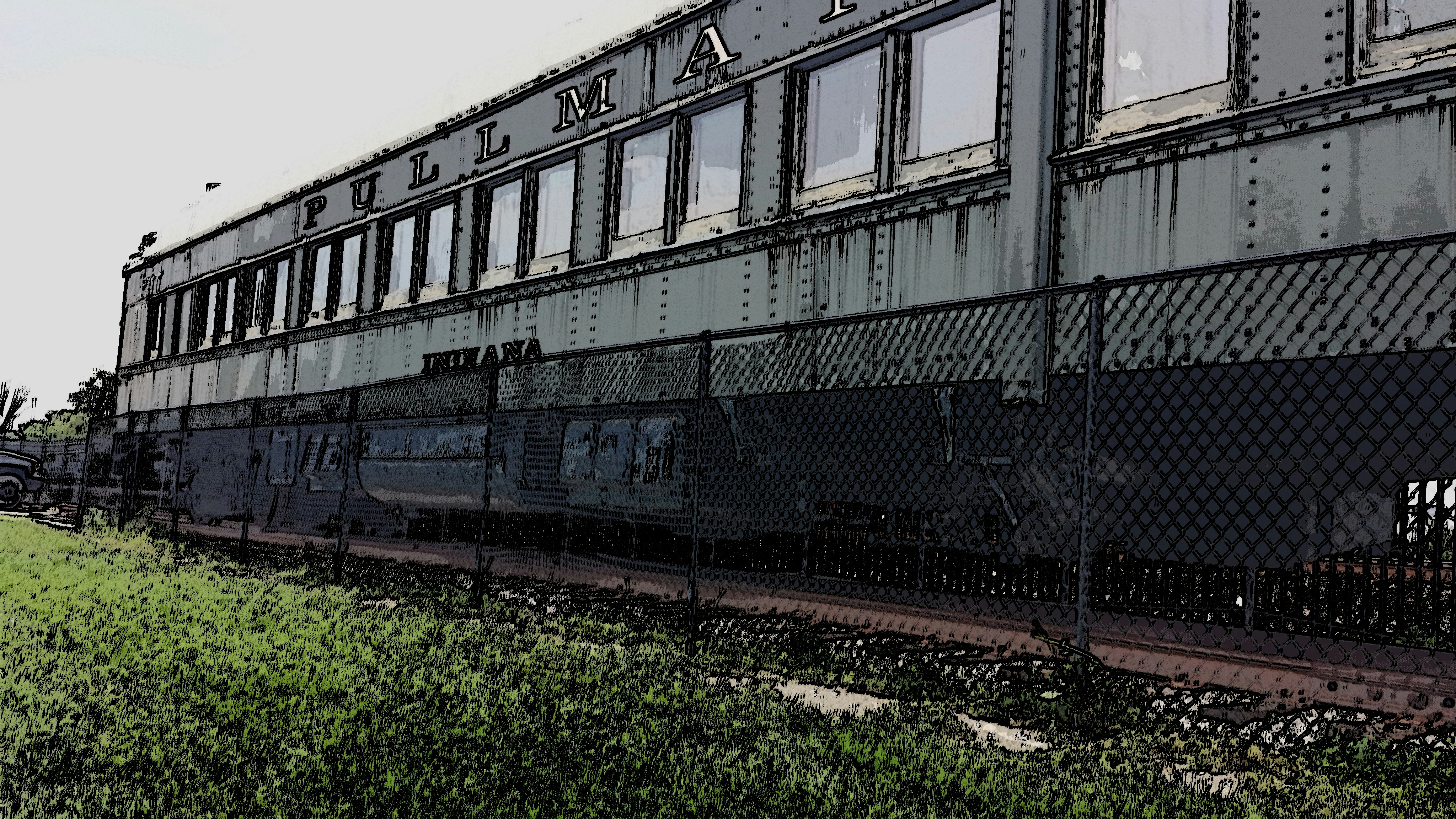 Derelict Pullman: A Weathered Railcar Beyond the Fence