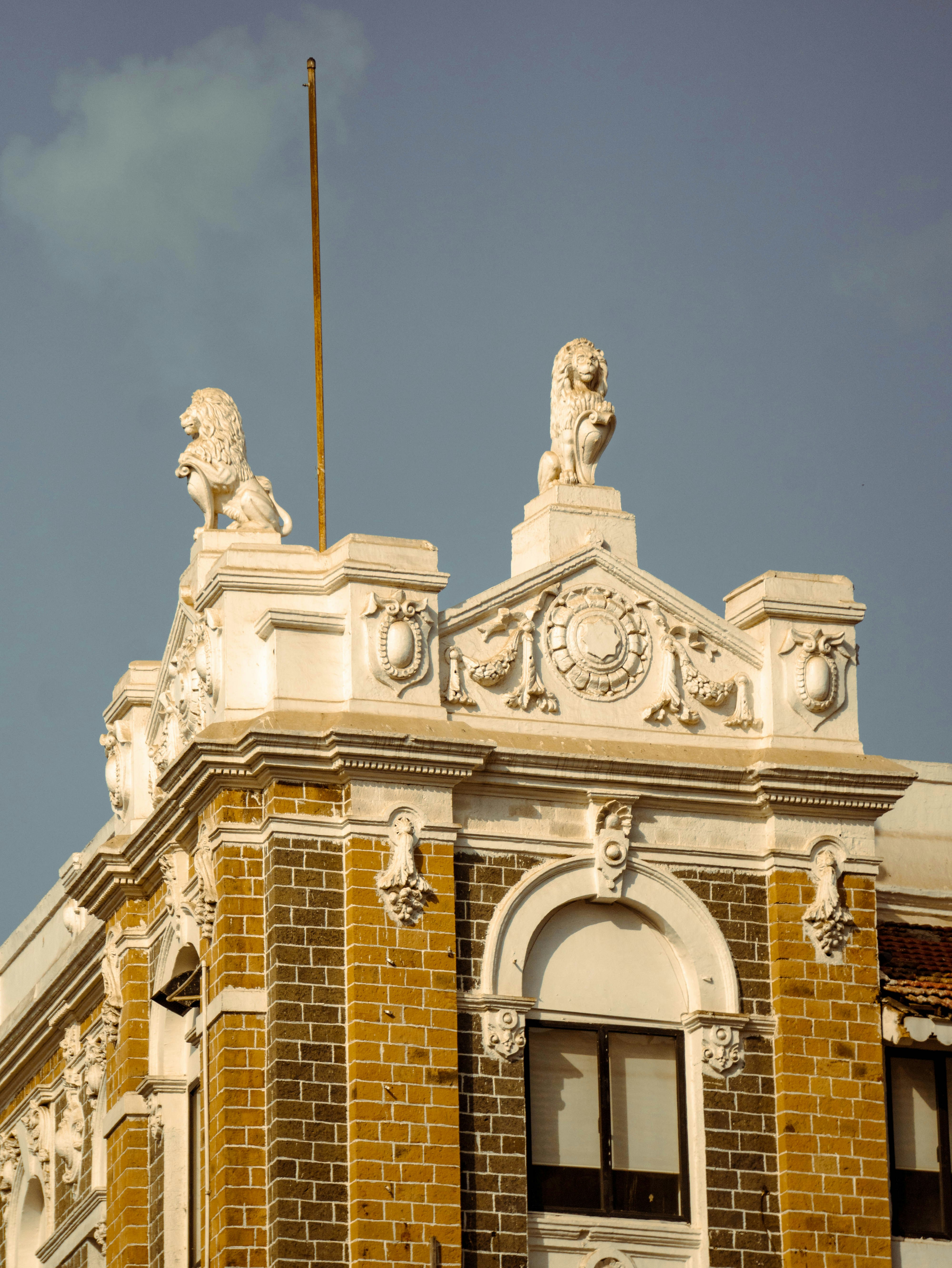 Ornate Roofline: Lions and Crest on a Historic Corner