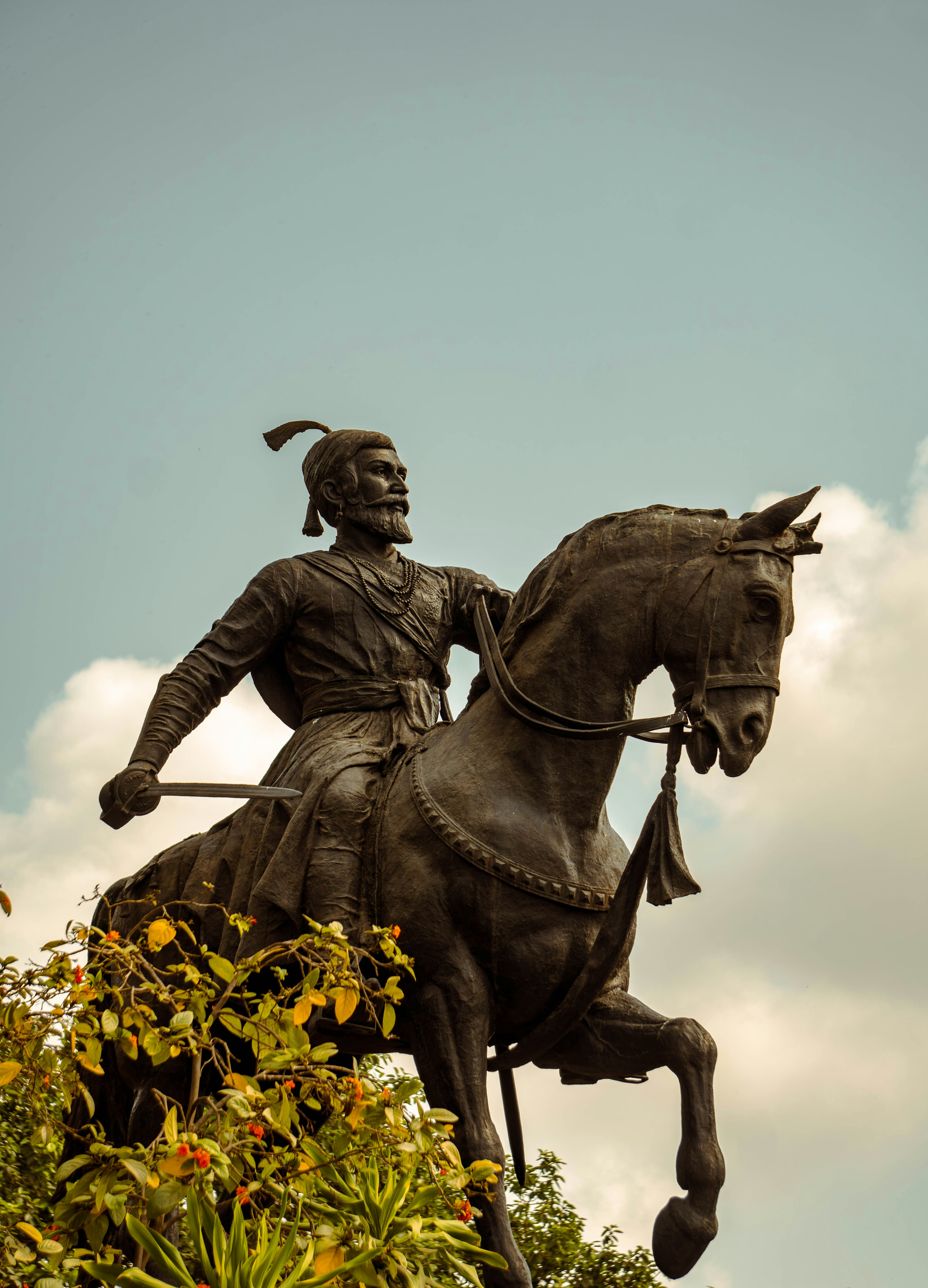 Equestrian statue of chhatrapati shivaji maharaj against a cloudy sky.