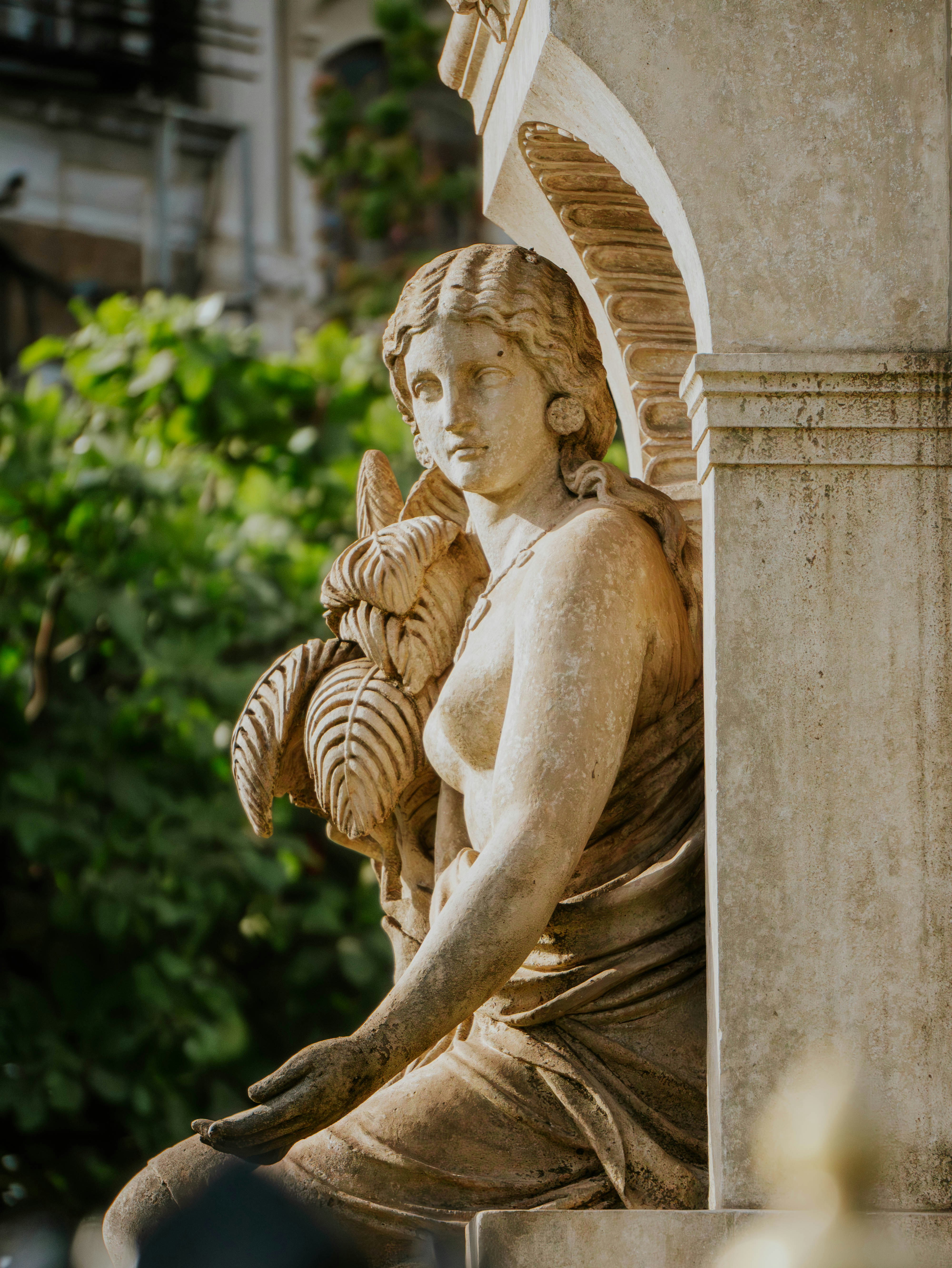 Sculpted Embrace: A Maiden with Foliage by the Arch