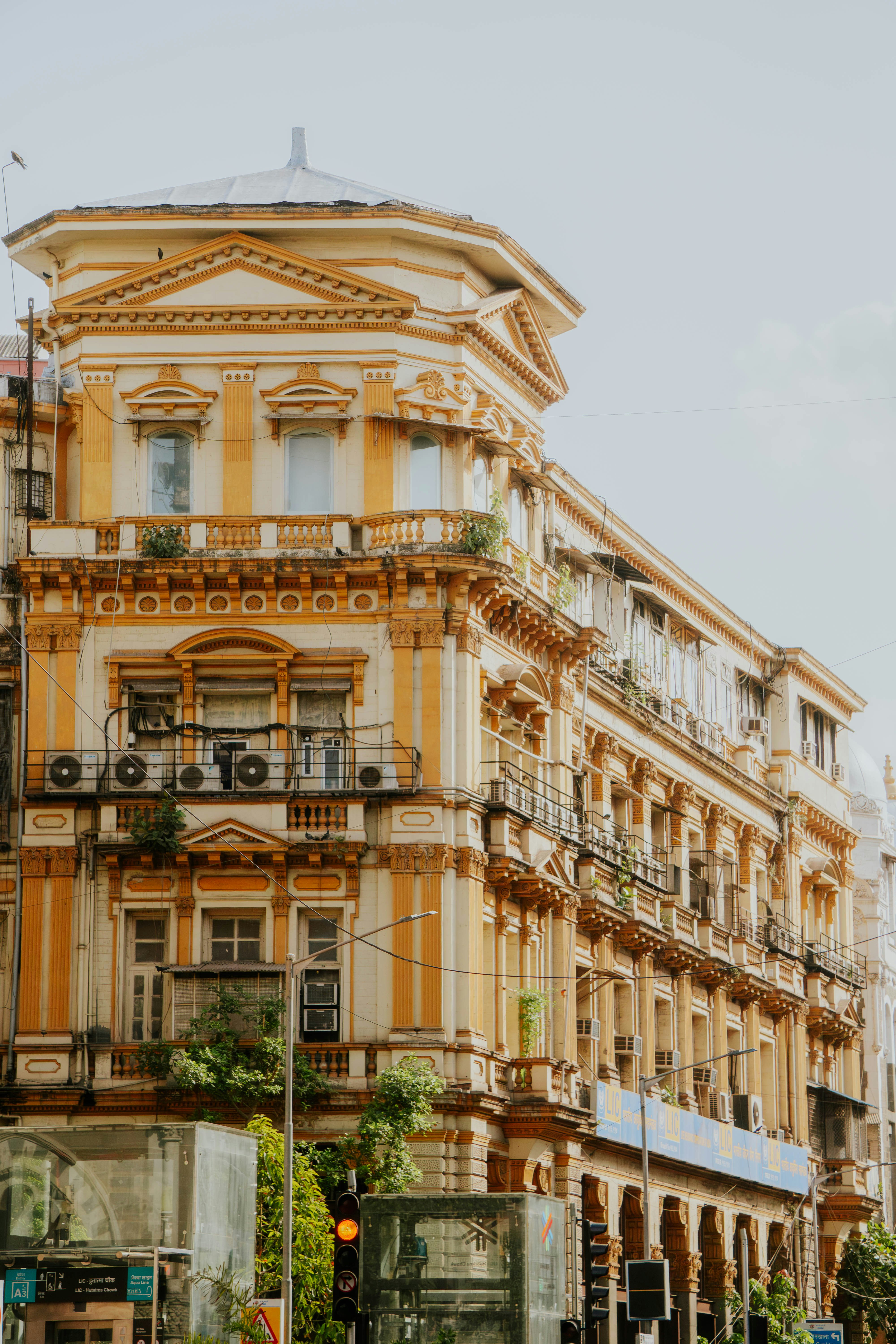 Sunlit yellow townhouse cascade brightened by ornate cornices