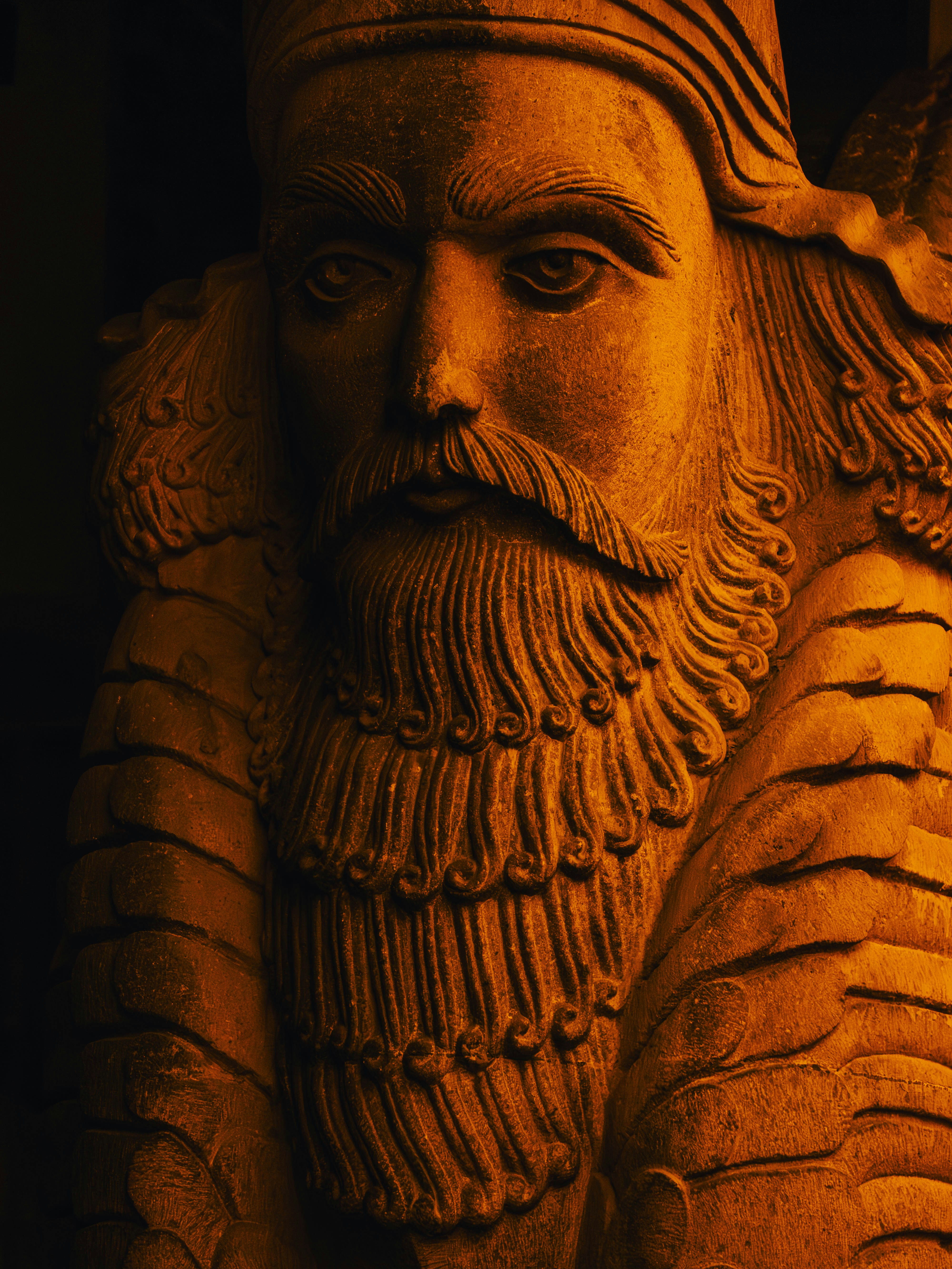 Detailed stone carving of a bearded man with a headdress.