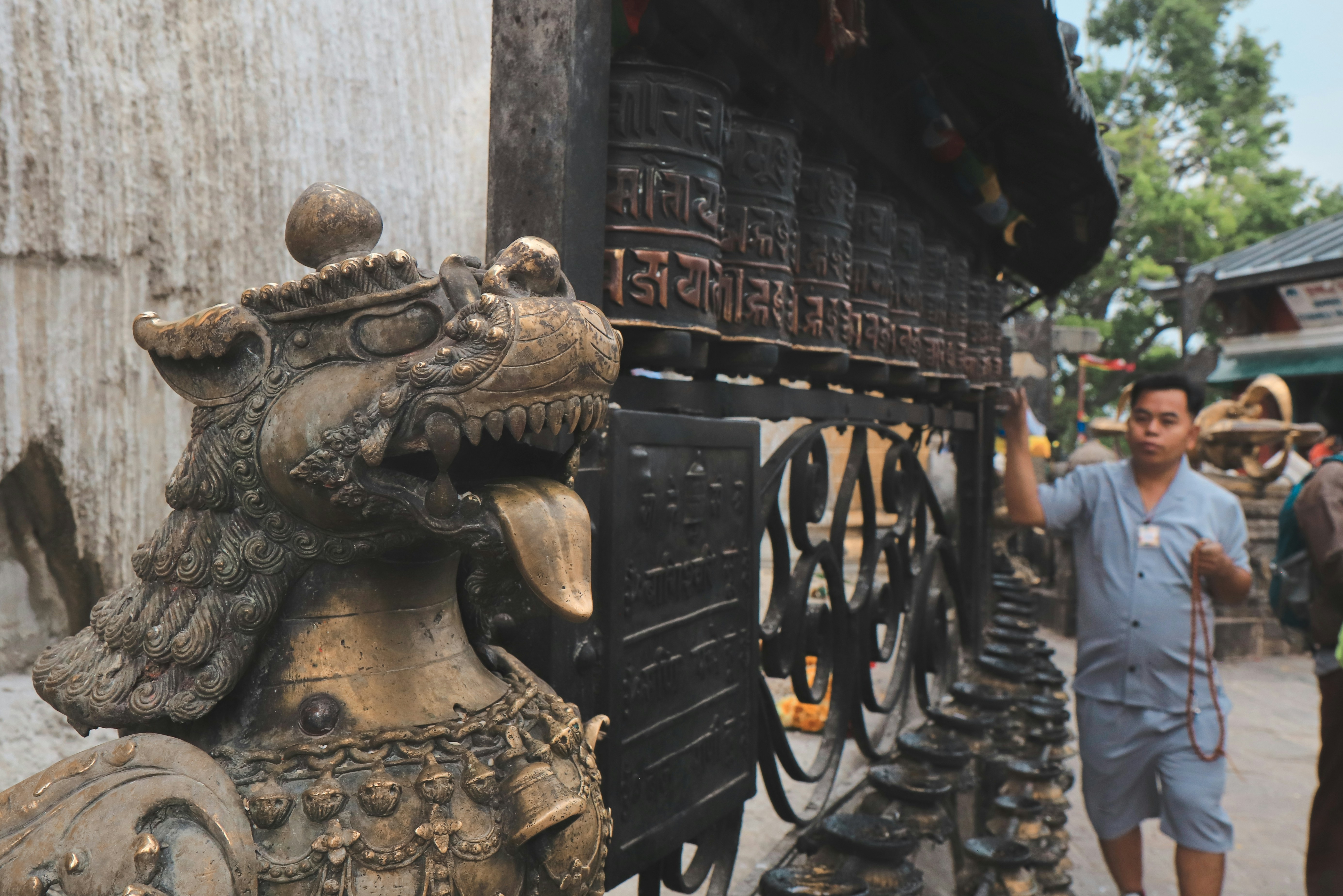 Dragon-head guardian and distant visitors at a temple side