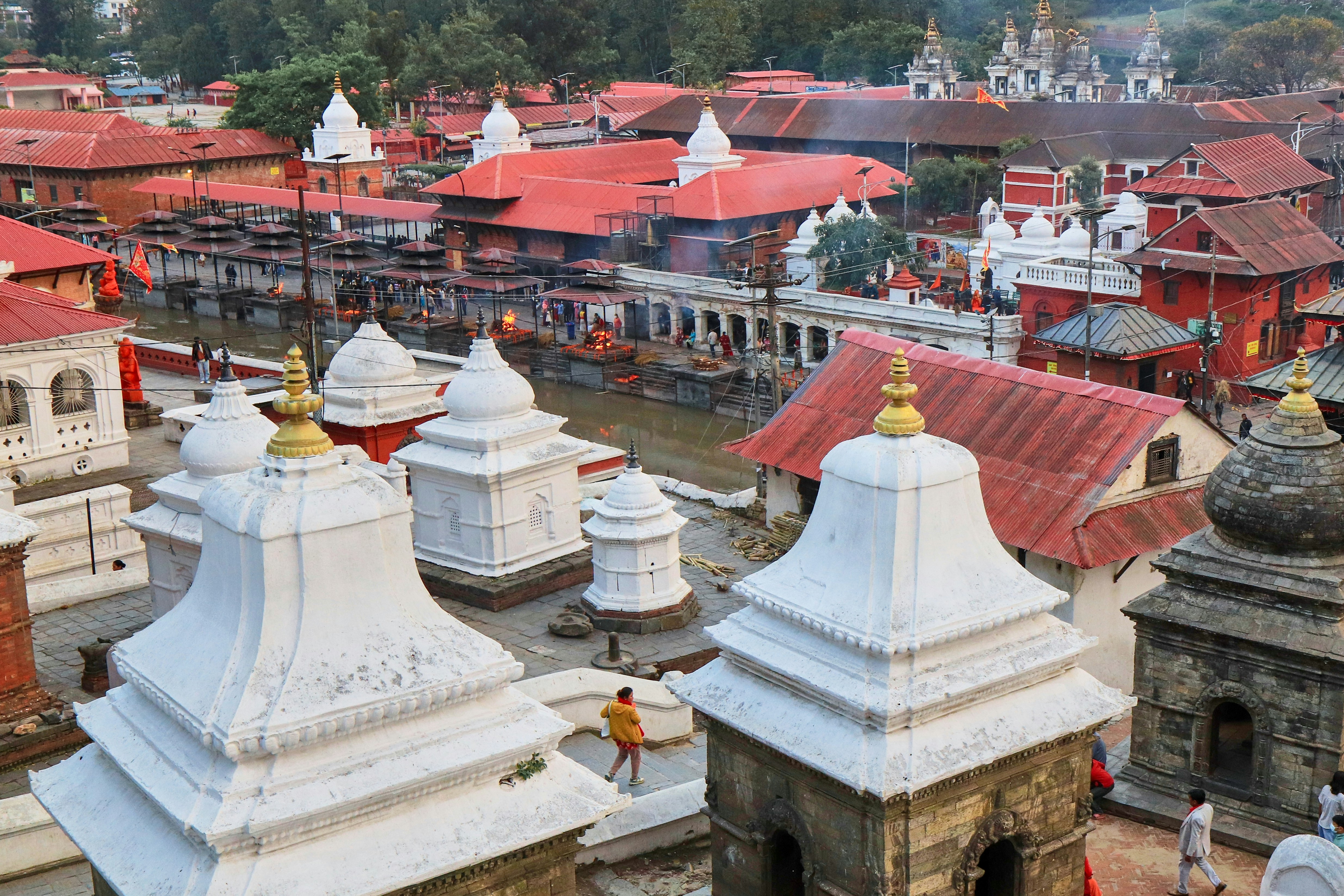 Ancient temple complex with white shrines and red roofs.
