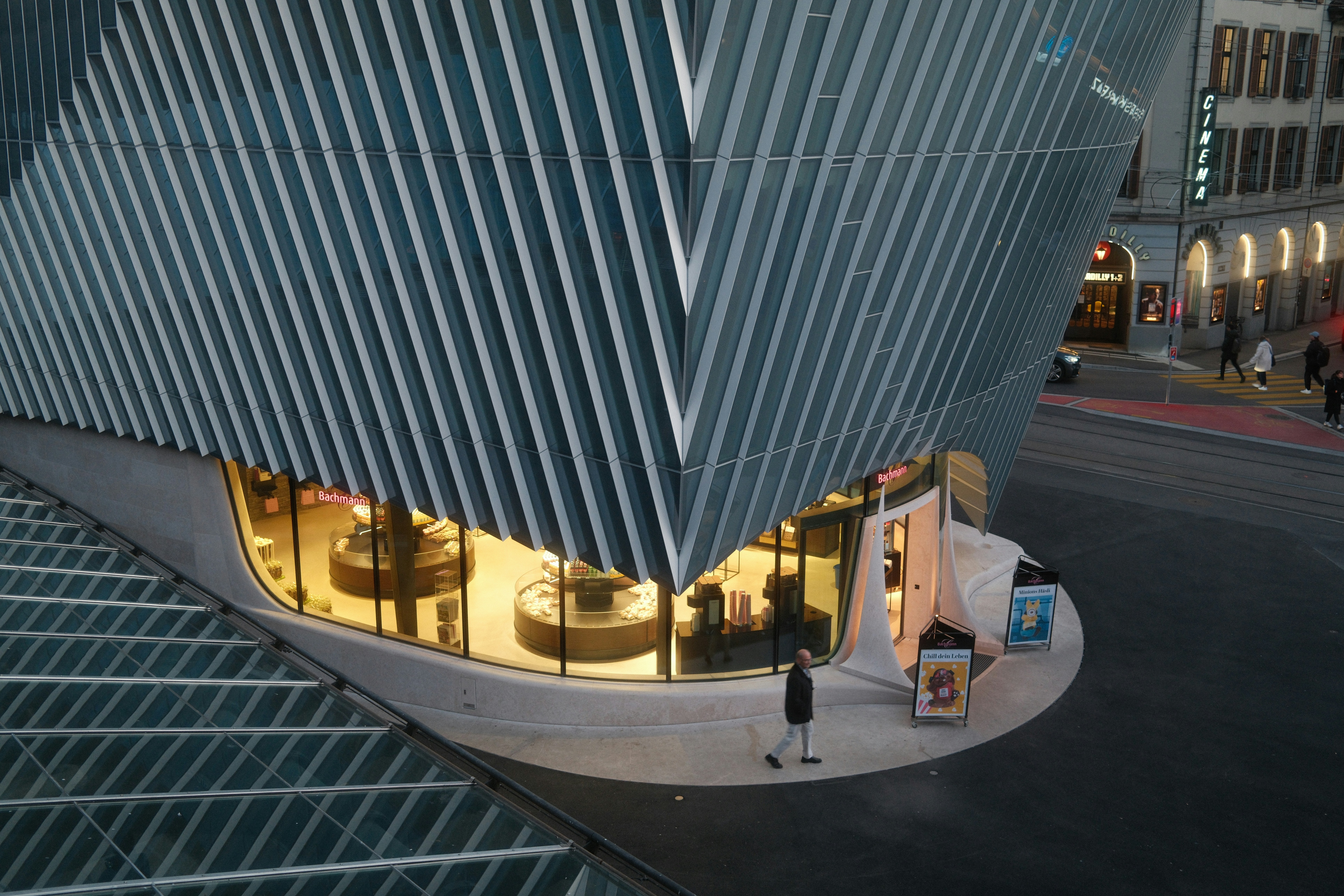Modern building with a curved facade and illuminated storefront.