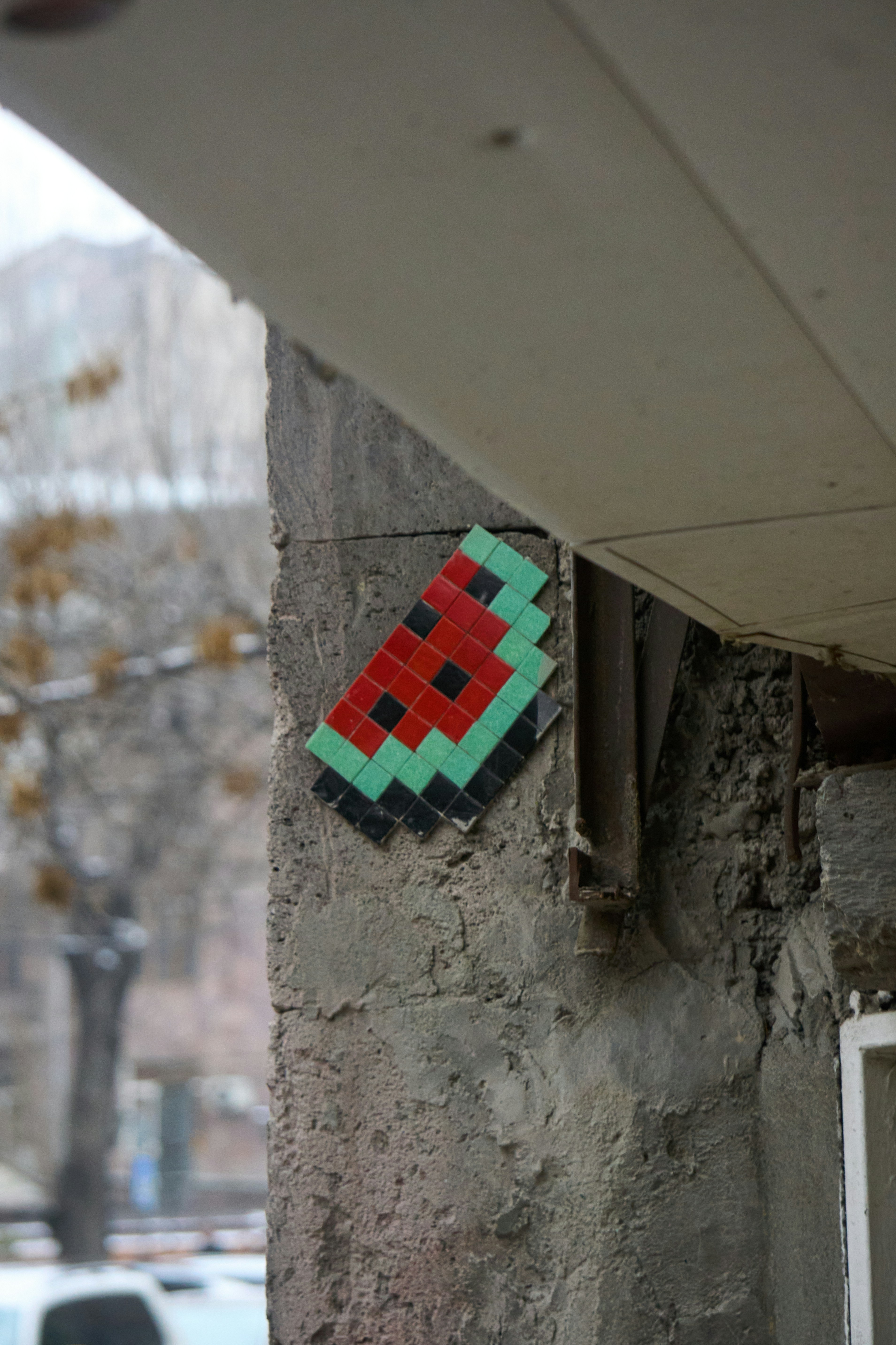 Pixel Mosaic on Crumbling Brick: A Watermelon Tile Adorns the Corner