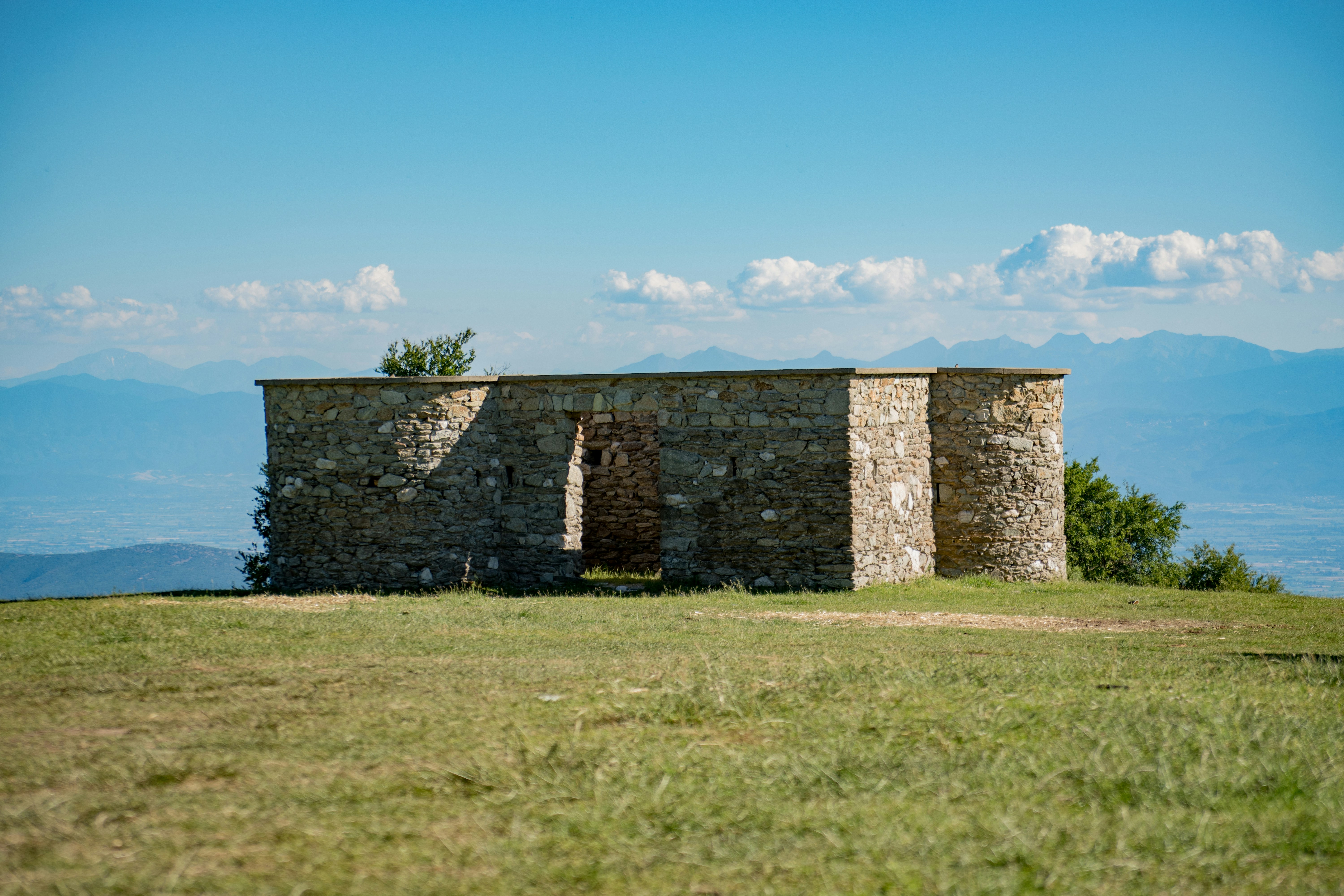 Stone Shelter on a Hilltop Under a Bright Blue Sky