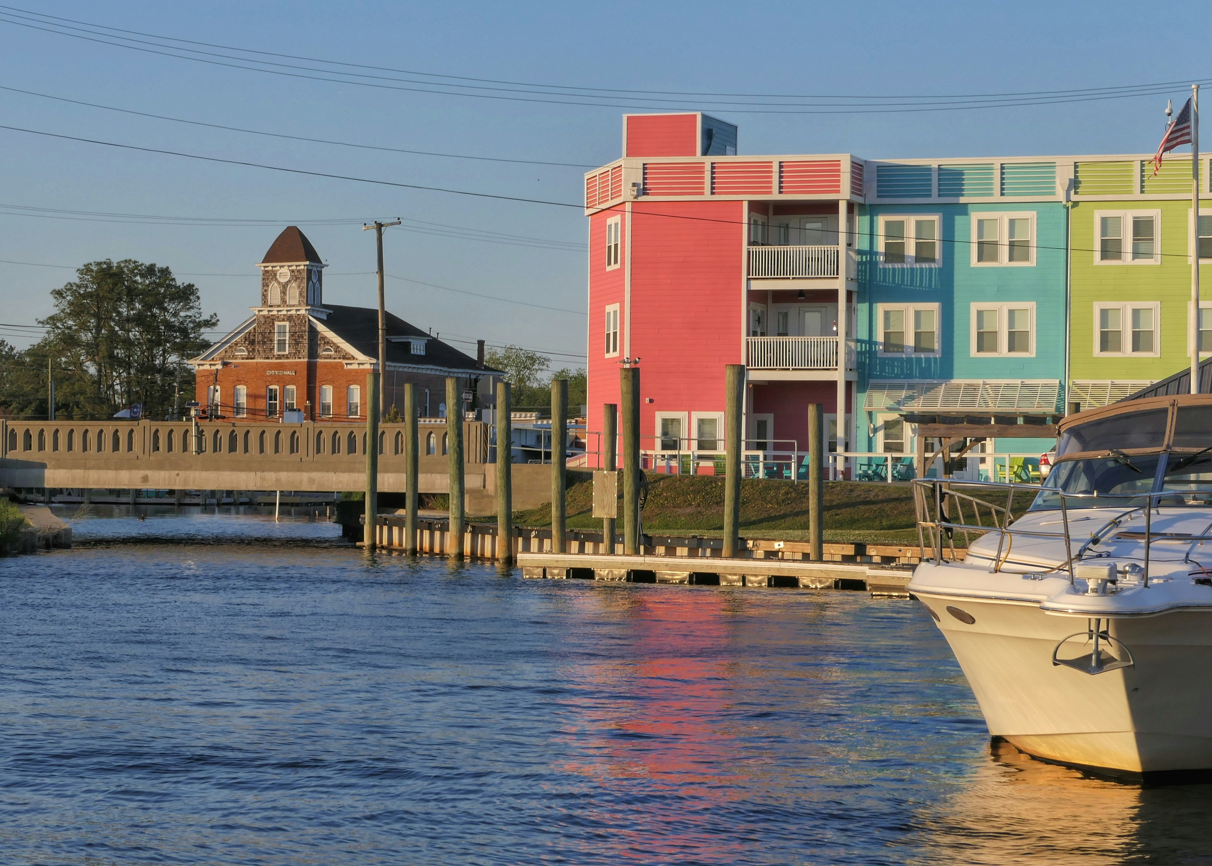 Colorful Riverside Row: Boats, Brick Church, and a Waterfront Walk