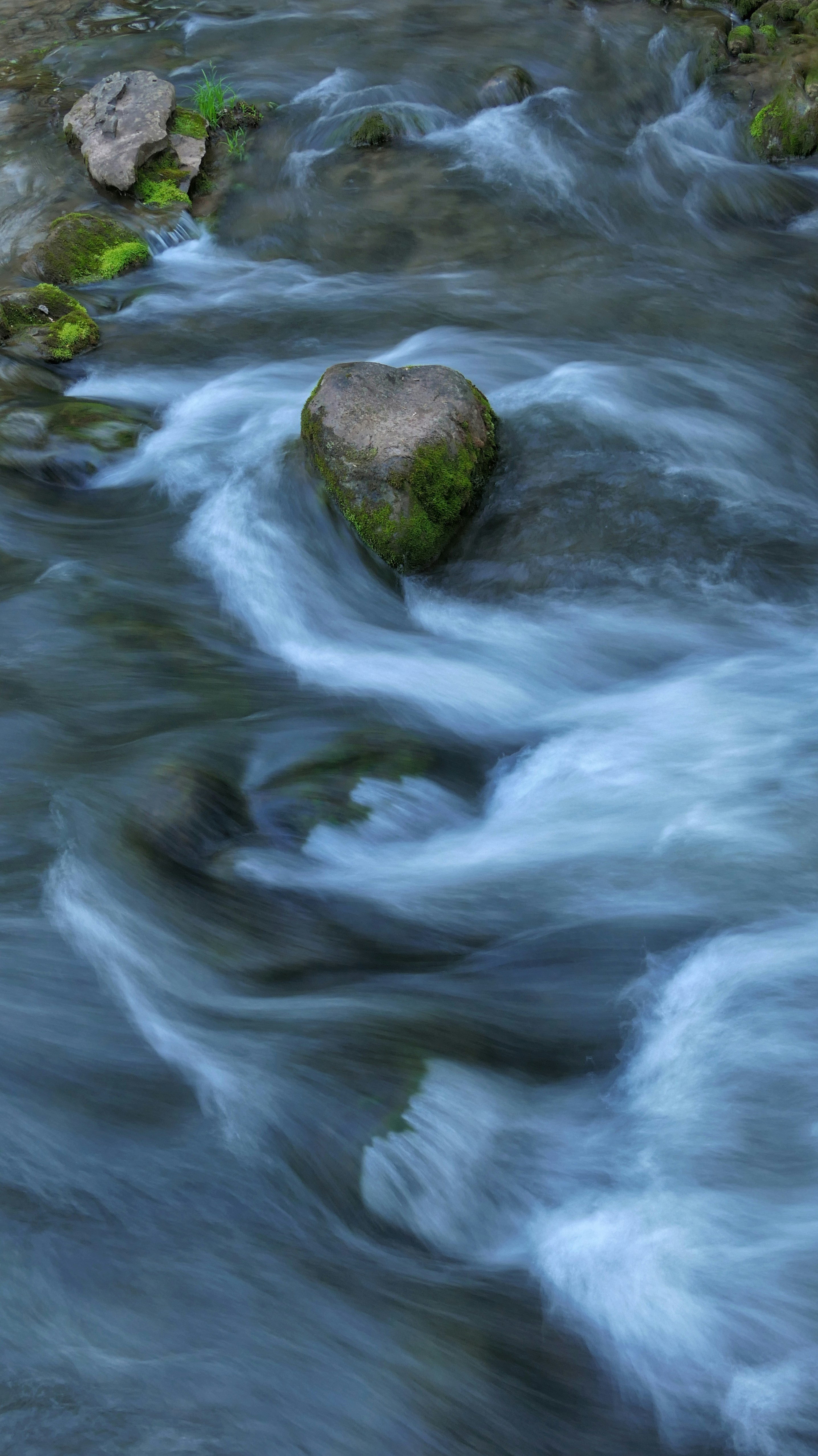 slow speed capture of river current around rocks