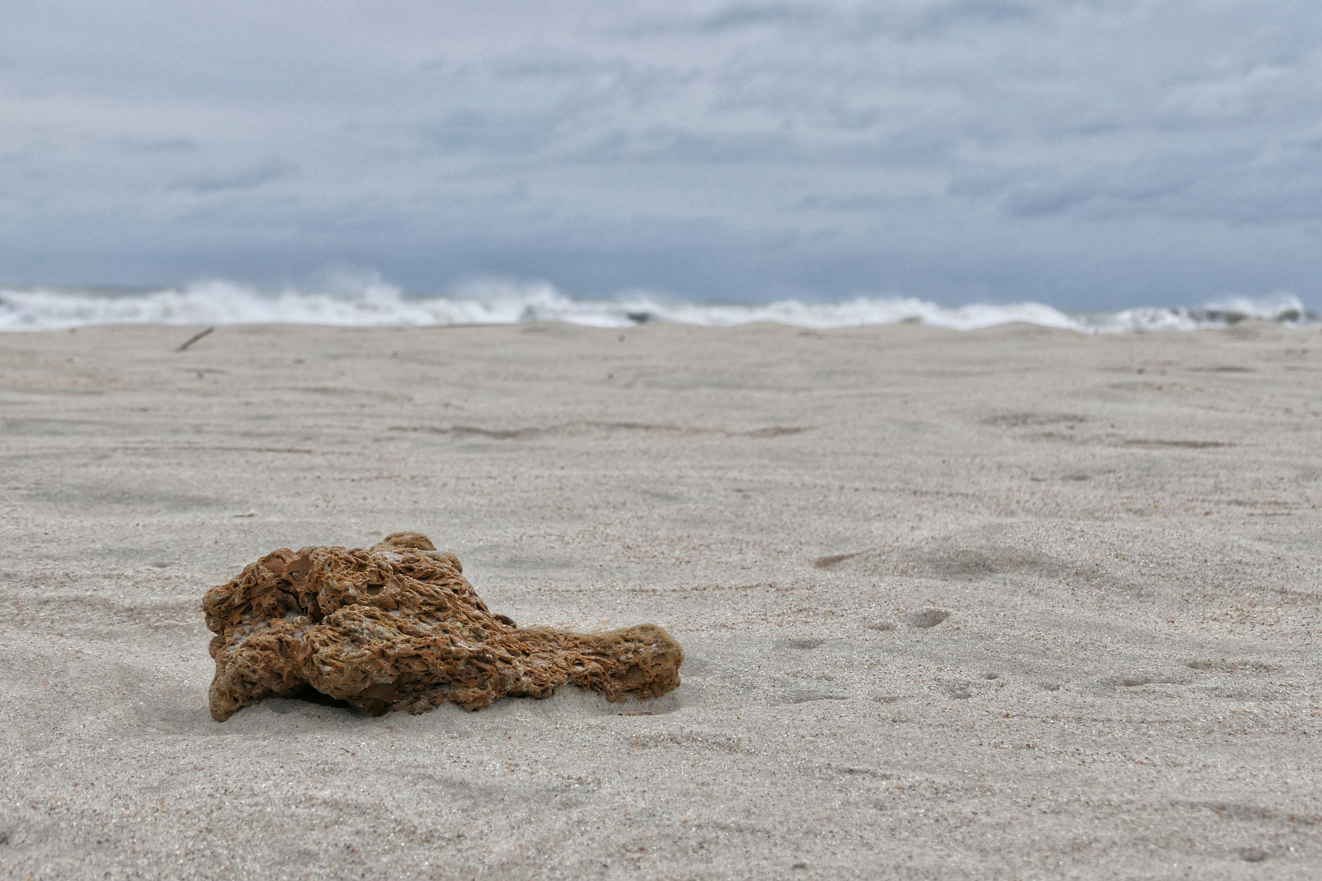 Lone Rugged Rock at the Edge of Quiet Sand