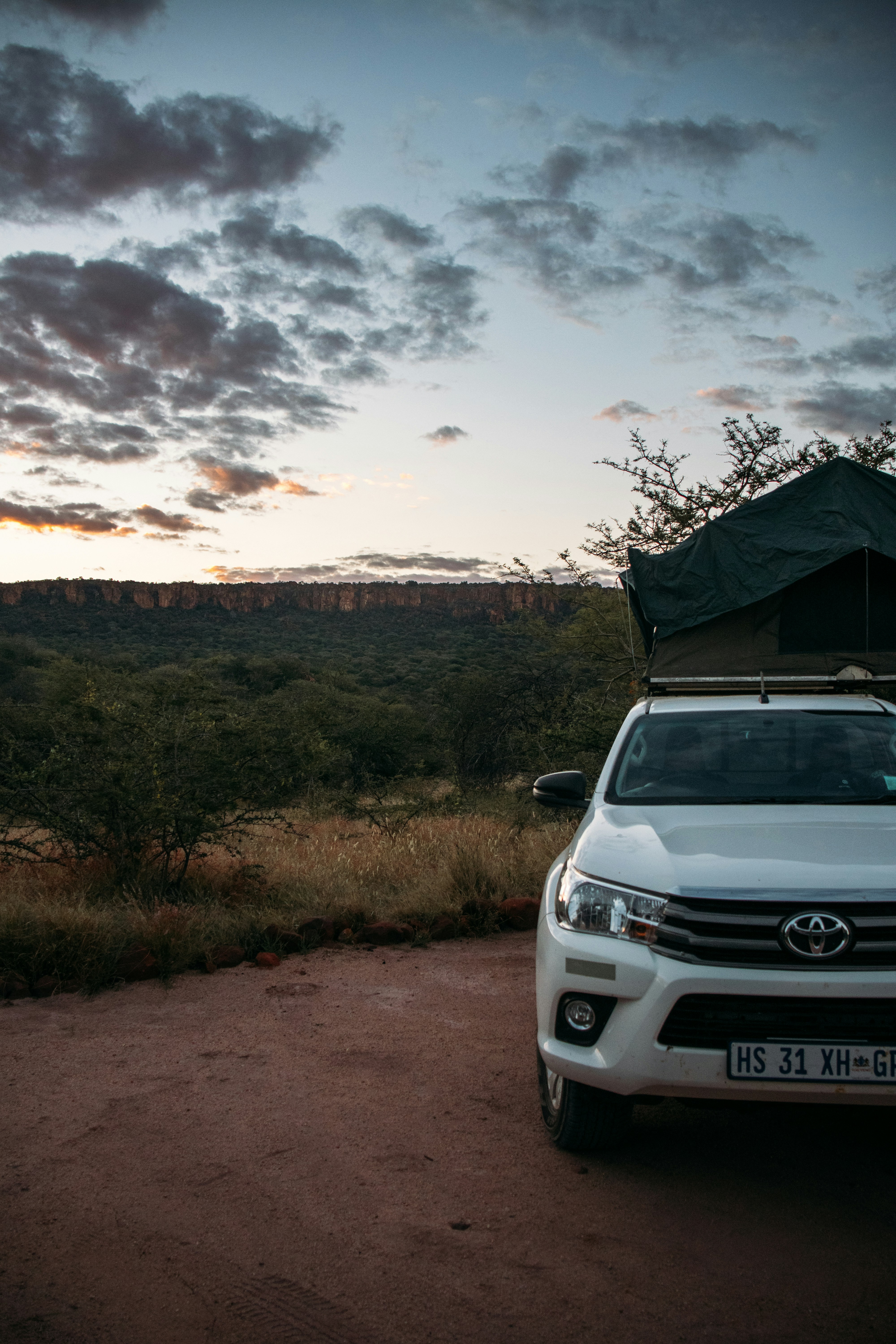 Desert Sunset Camp: A White Toyota Pivoting toward the Horizon