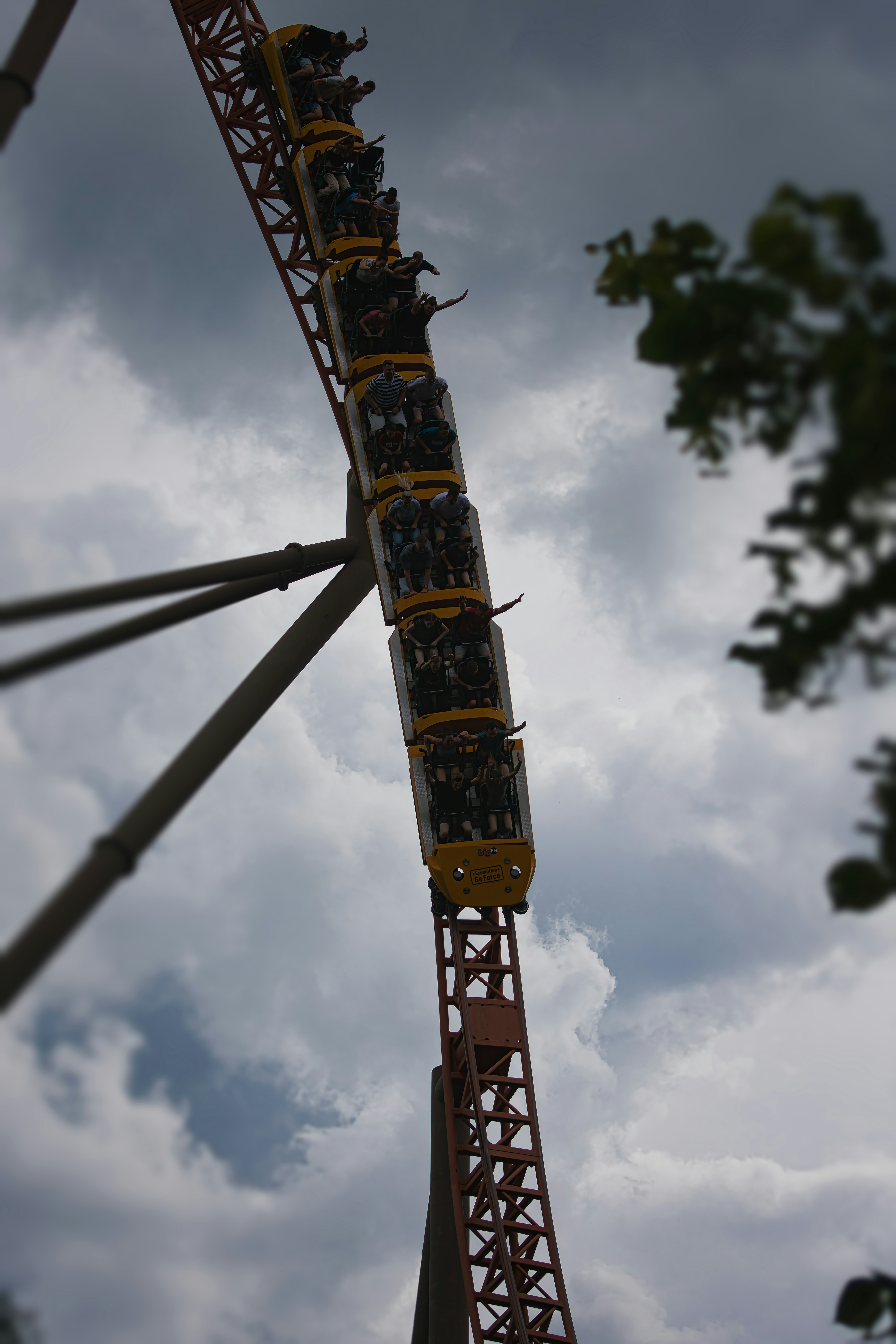 Ascending Thrill: Aerial View of a Yellow Roller Coaster Car Plunging Through the Sky