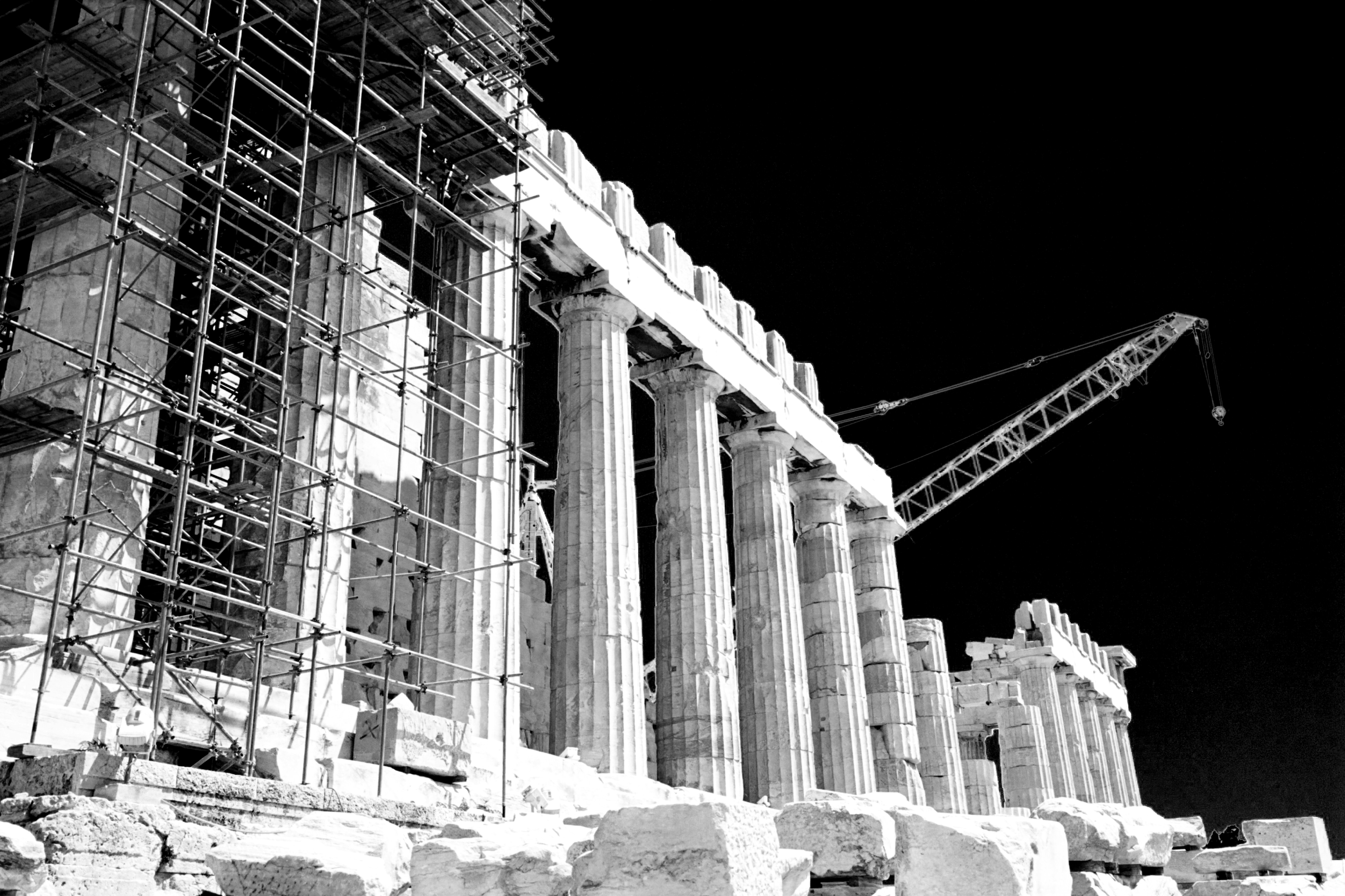 The parthenon undergoing restoration with scaffolding and a crane.