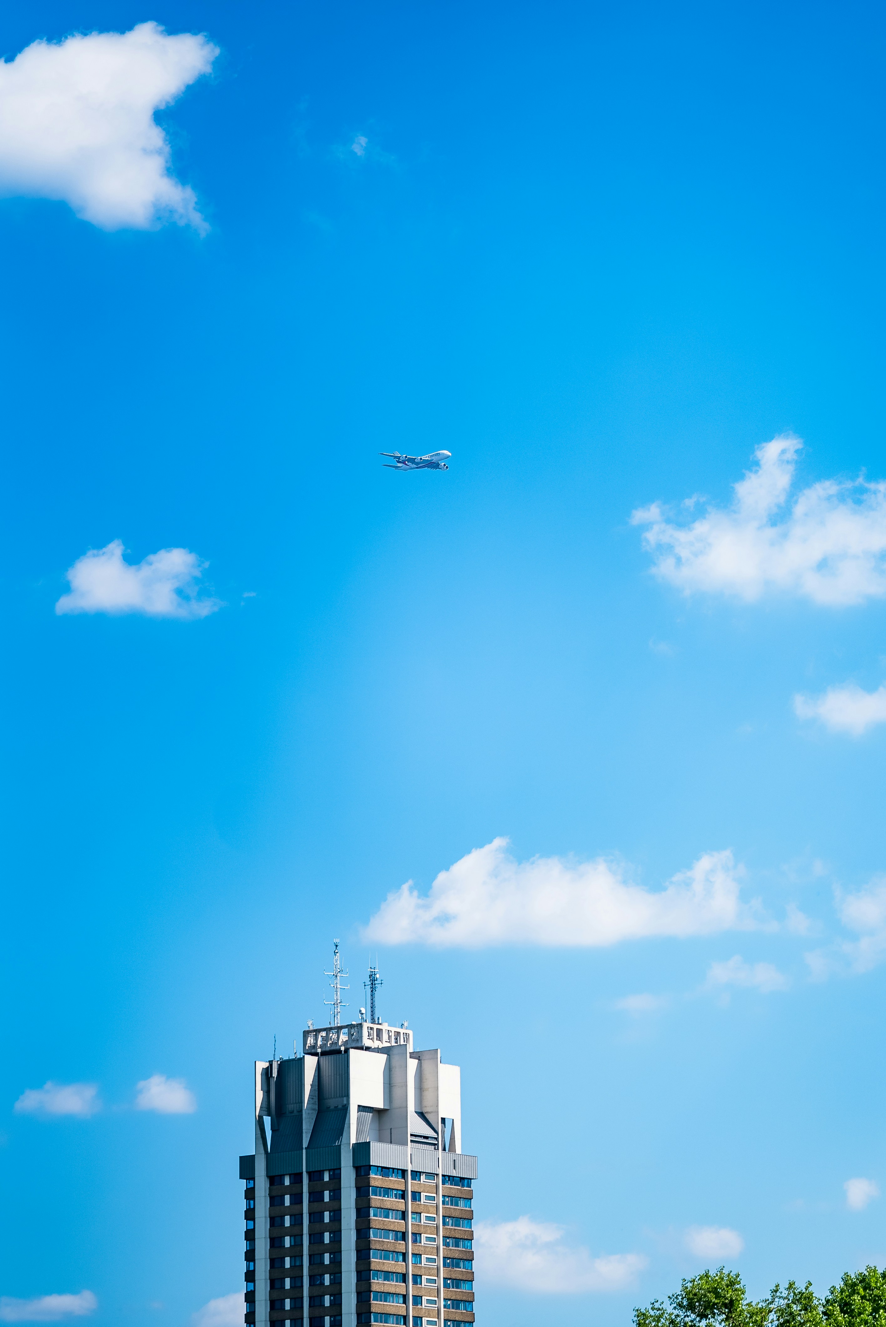 Jetliner over the City: A Clear Sky Above a Modern Summit